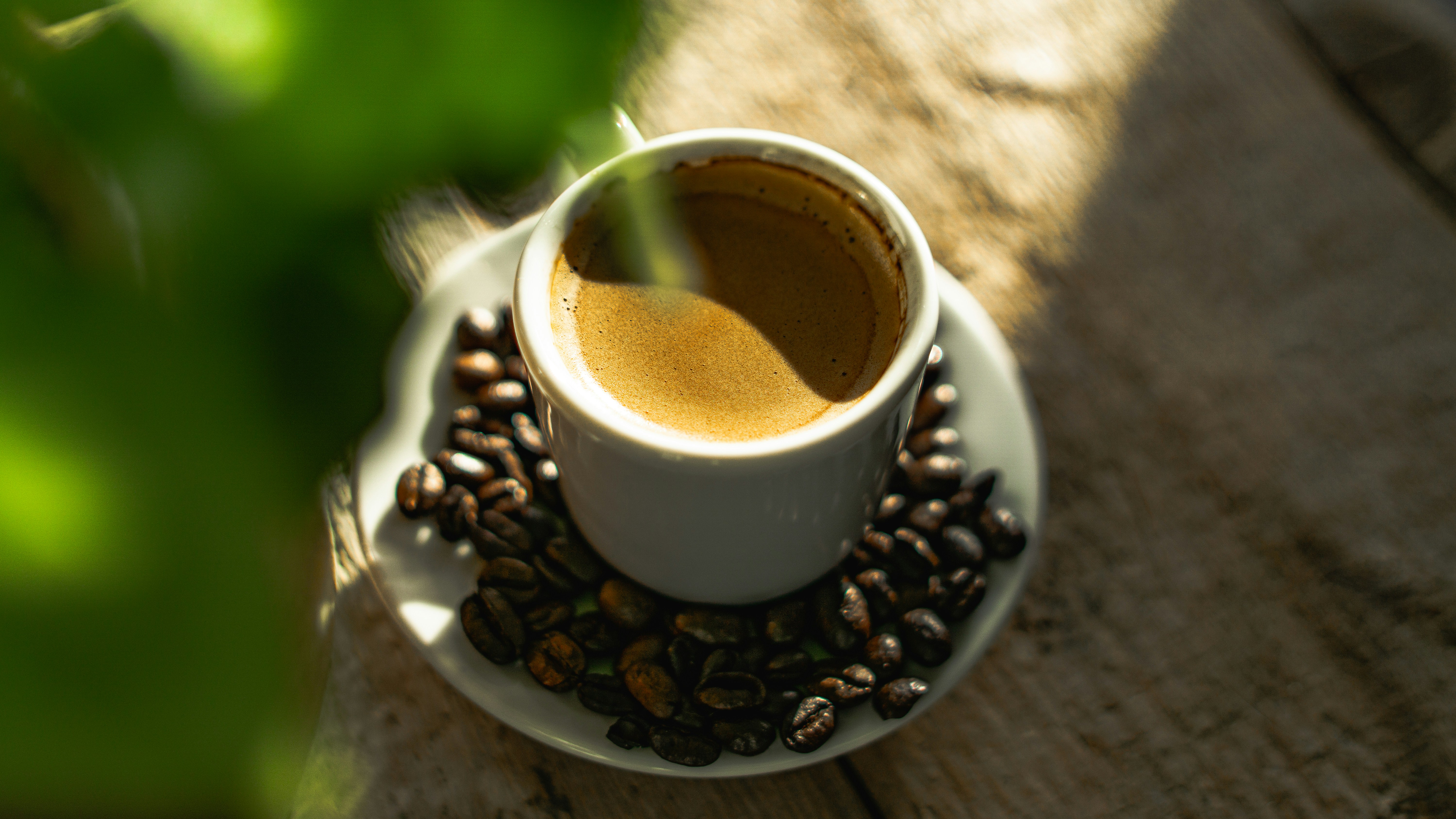 Crema Centerstage: Espresso Nestled Among Roasted Beans on Weathered Wood