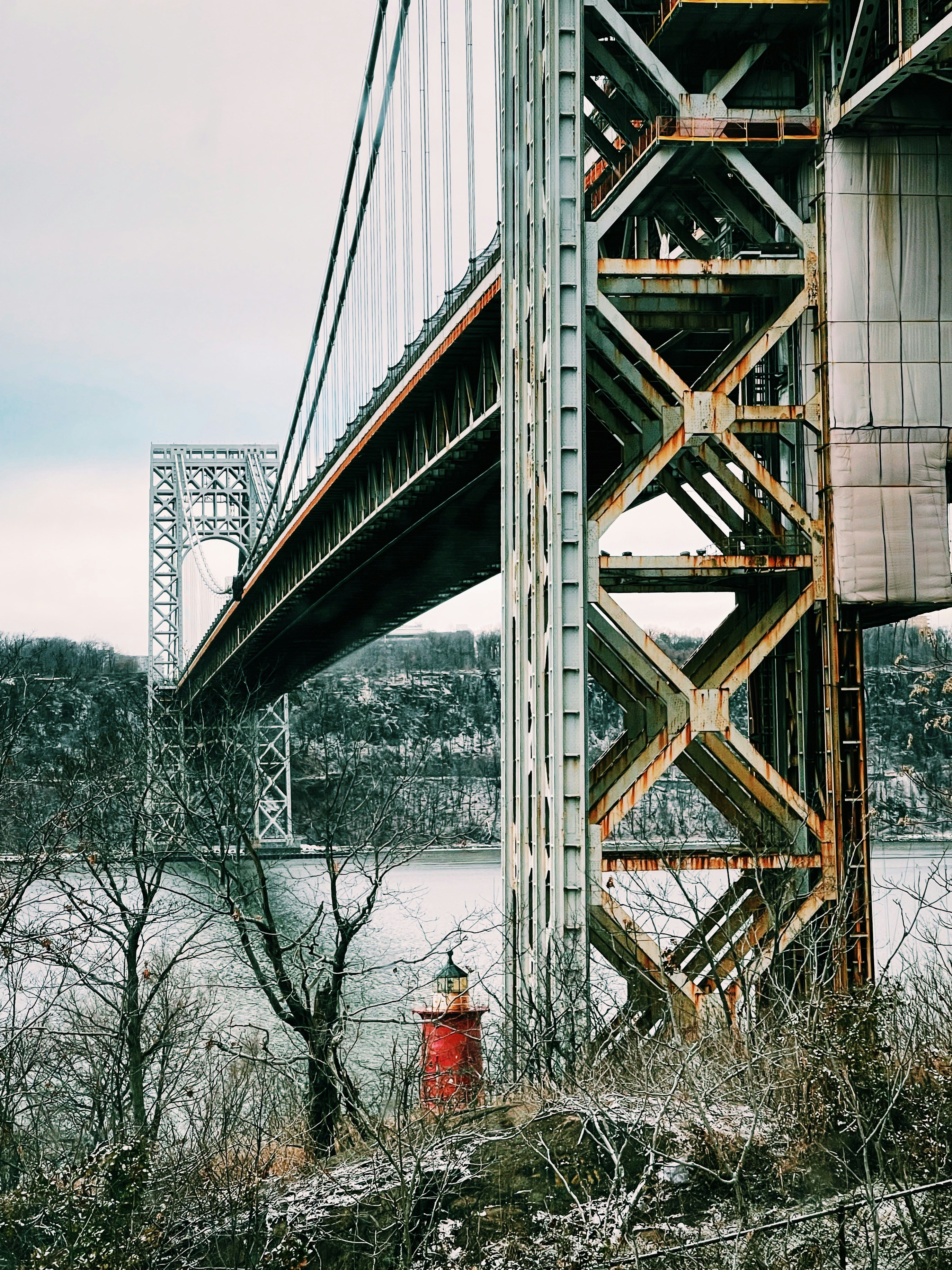 A red fire hydrant sitting in front of a bridge photo – Free Gwb Image ...