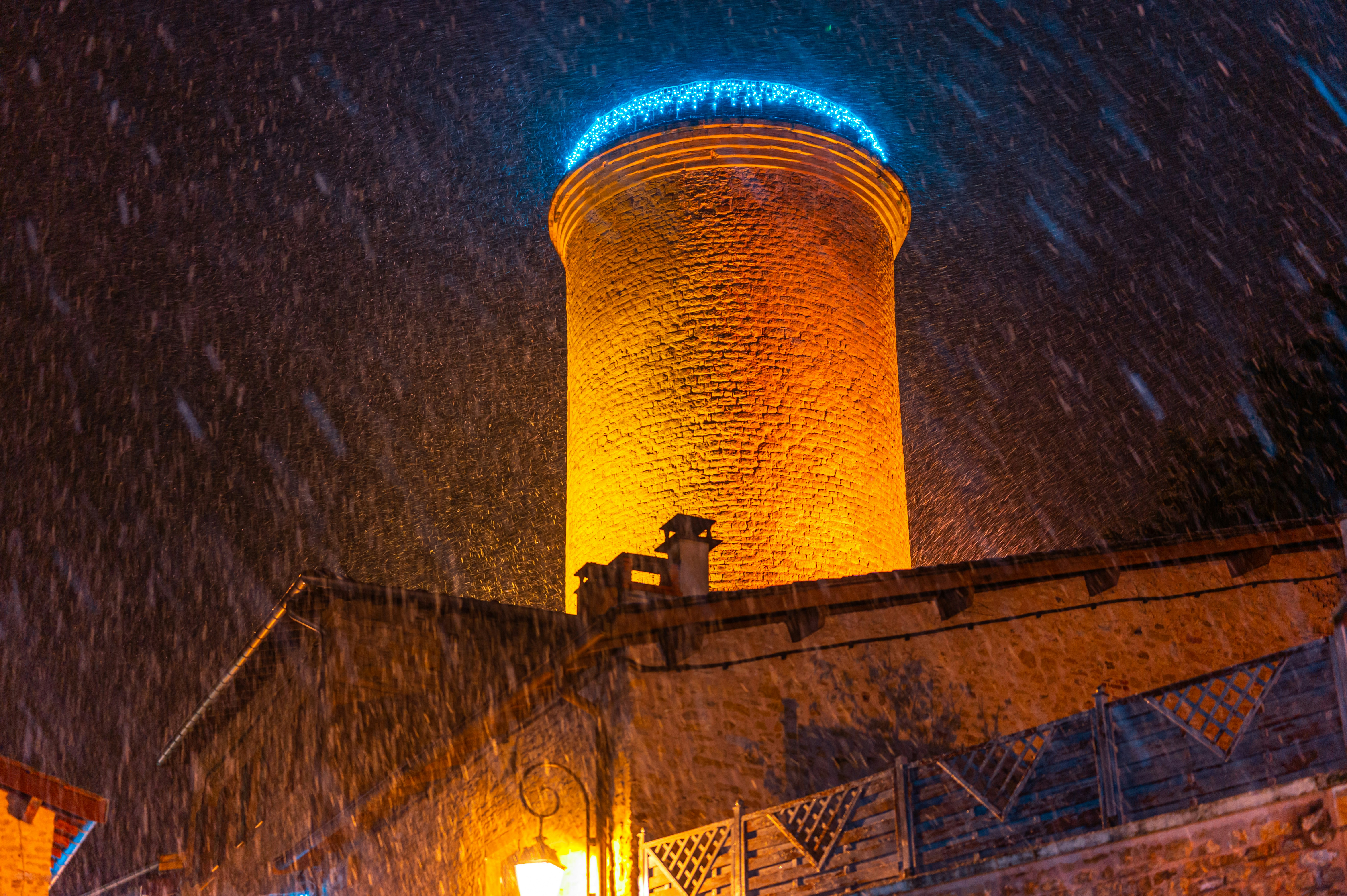 A tall tower with a blue light on top of it photo – Free Snow Image on ...