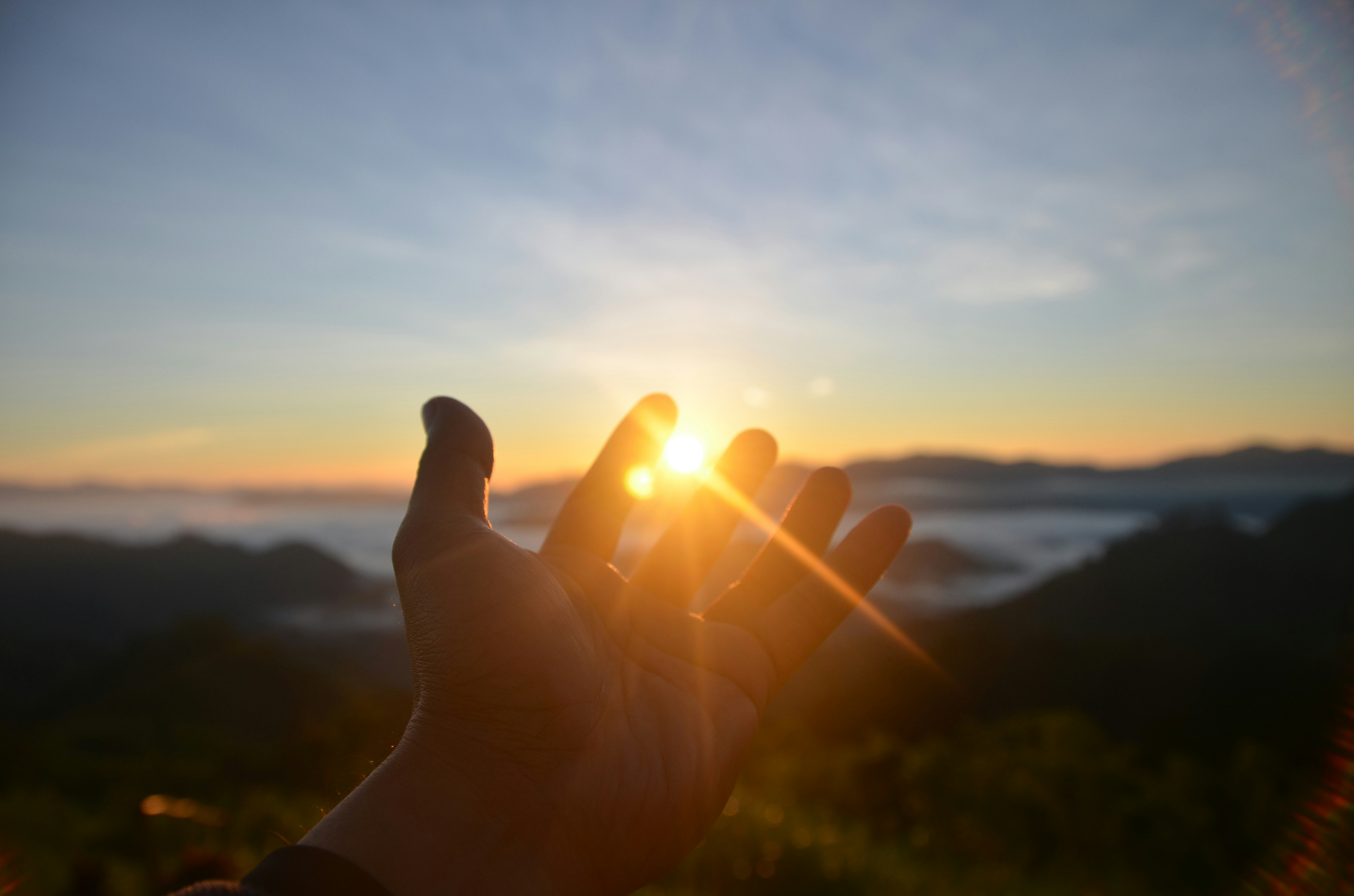 A person's hand holding up the sun in the sky photo – Free Nature Image ...