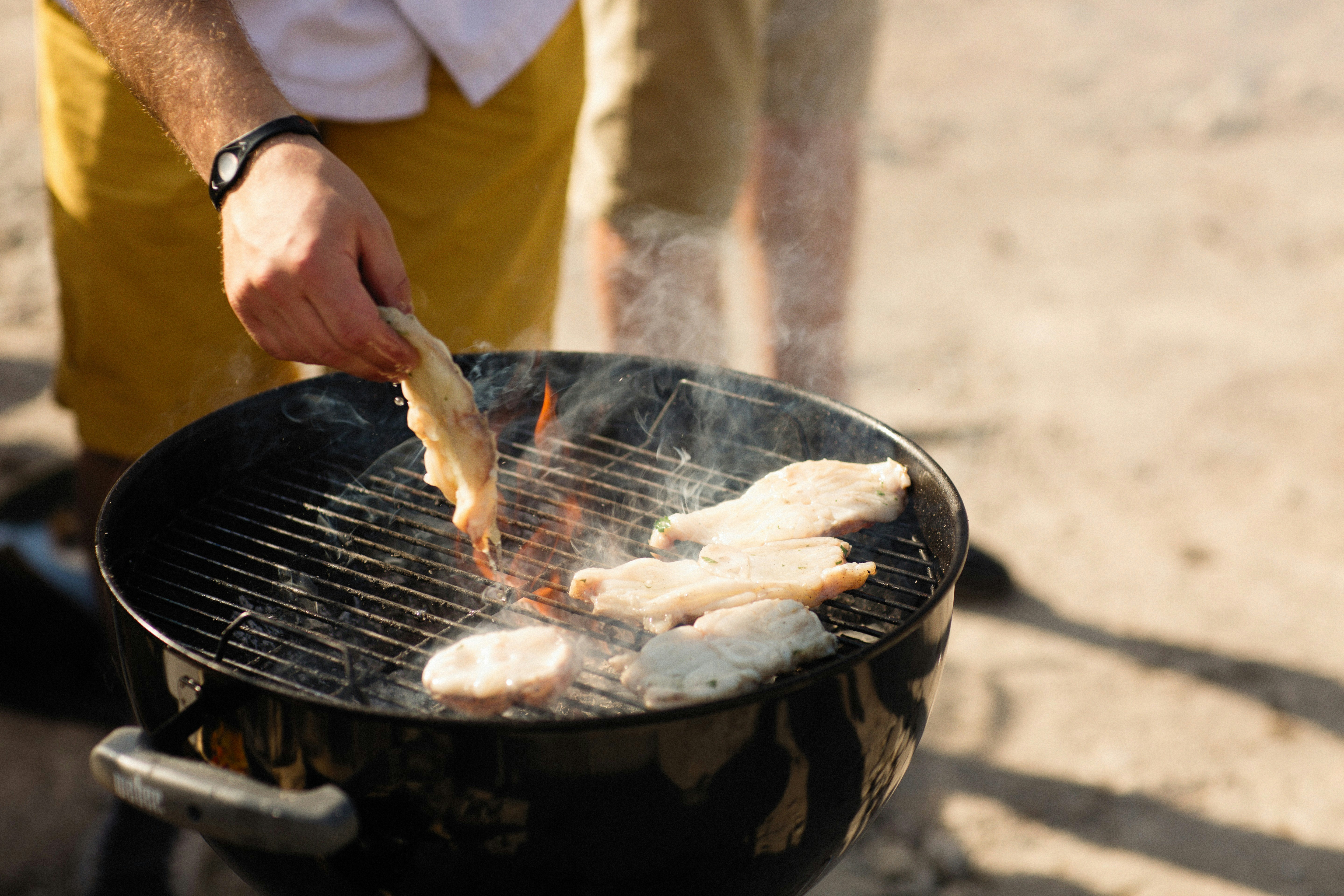 A man is cooking chicken on a grill photo – Free Human Image on Unsplash