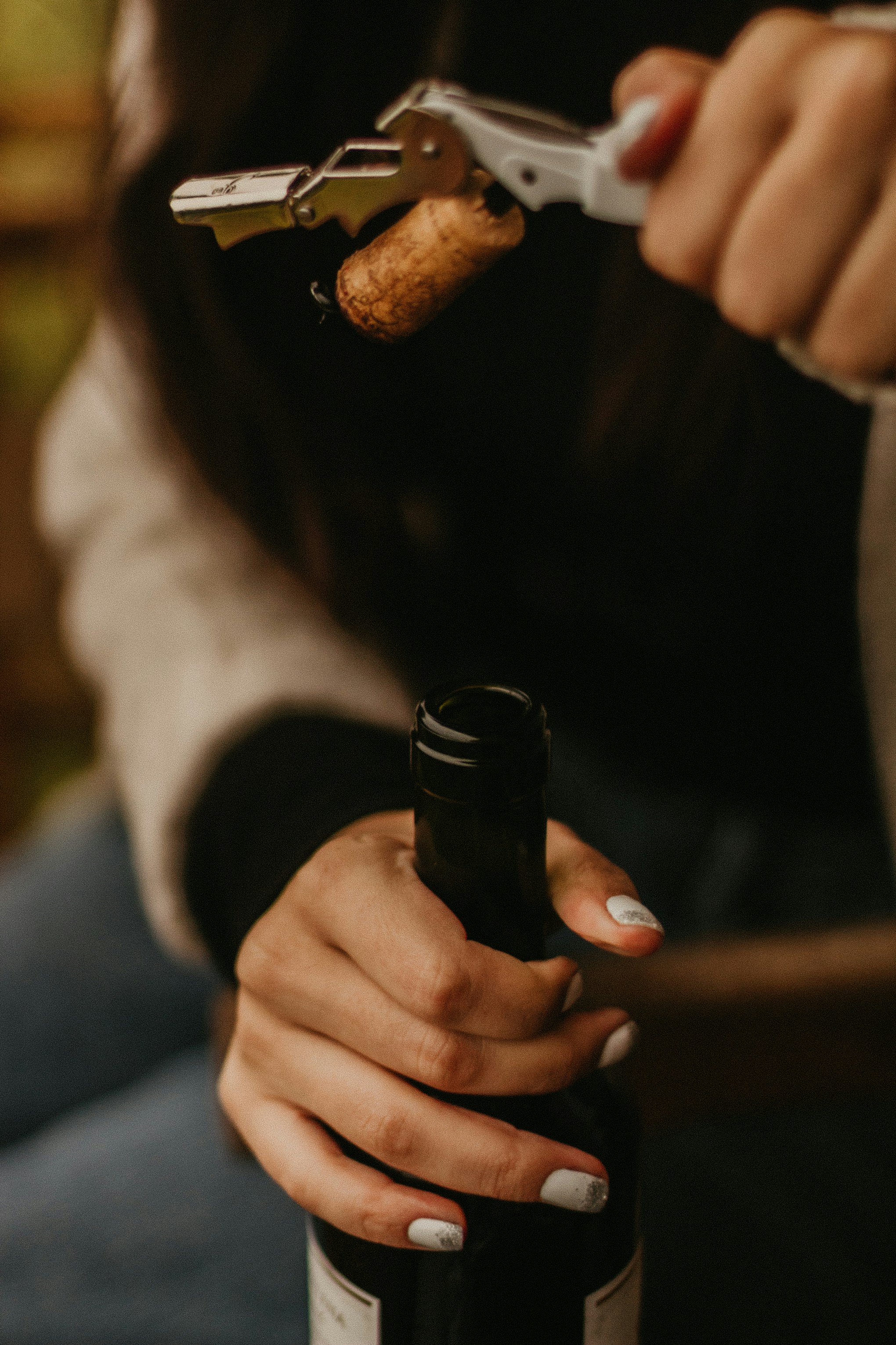 A woman holding a corkscrew and a bottle of wine photo – Free Wine ...