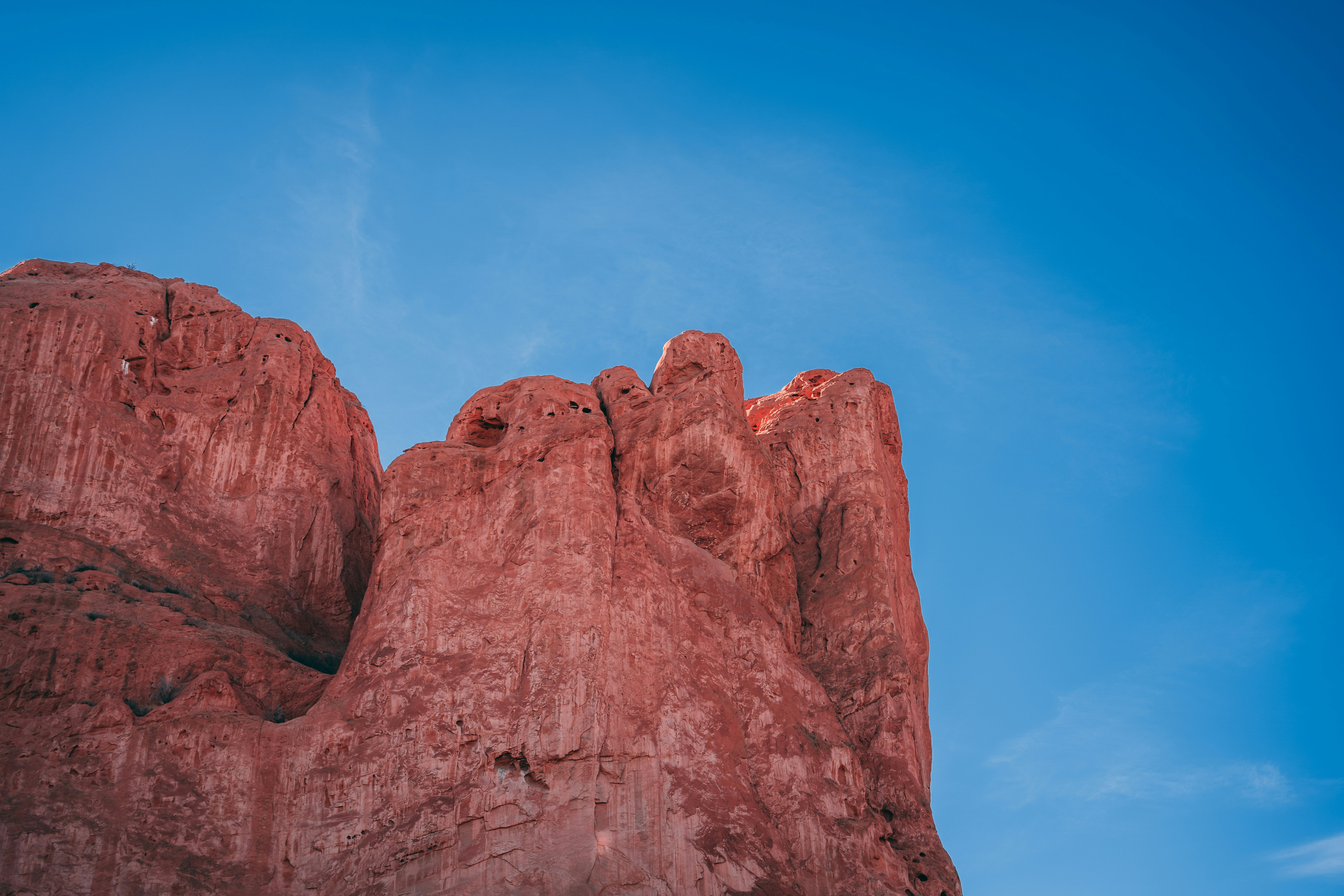 A red rock formation with a blue sky in the background photo – Free ...