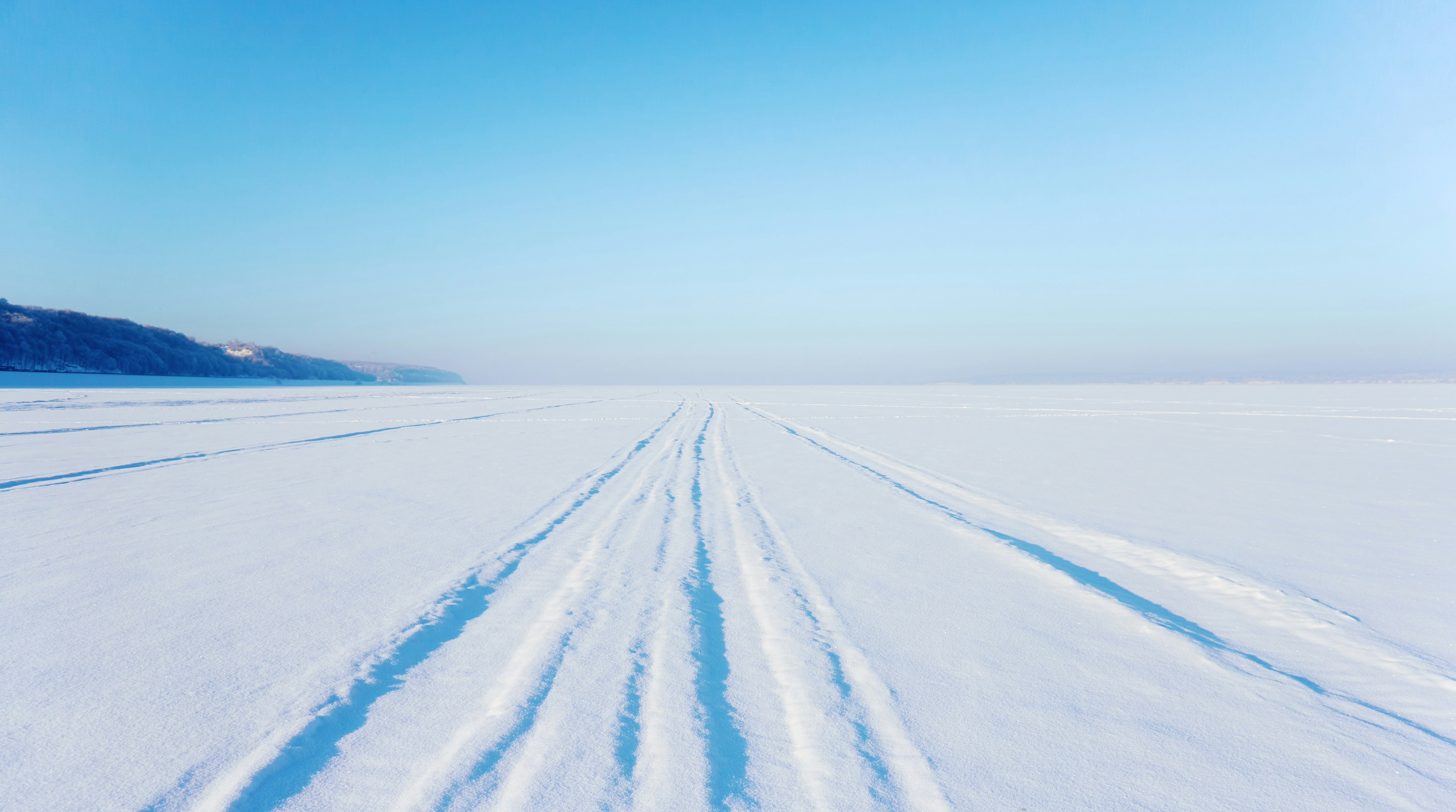 A wide expanse of snow with a mountain in the distance photo – Free ...
