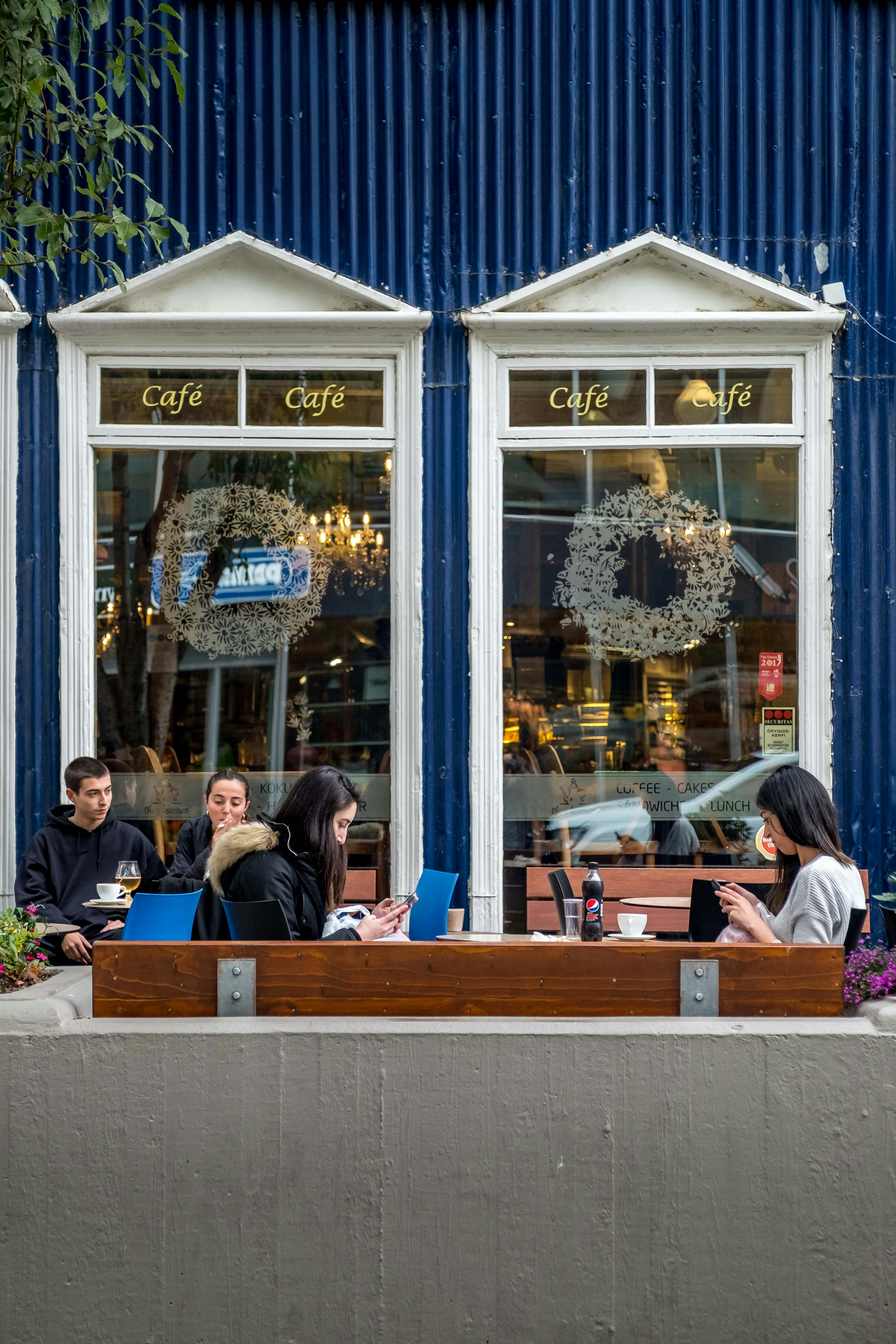 Café Portraits Across a Blue Facade
