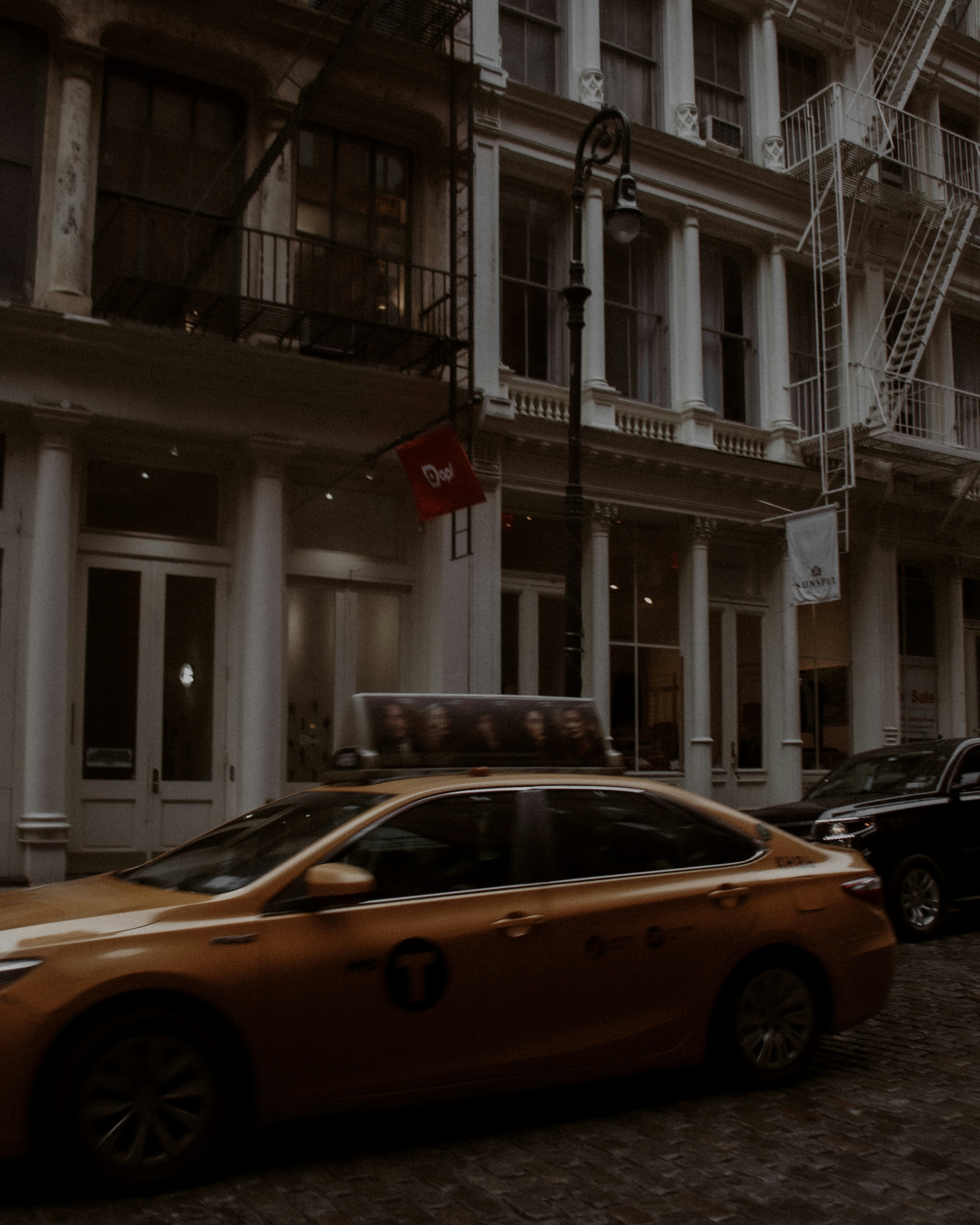A taxi cab parked in front of a tall building photo – Free Soho Image ...