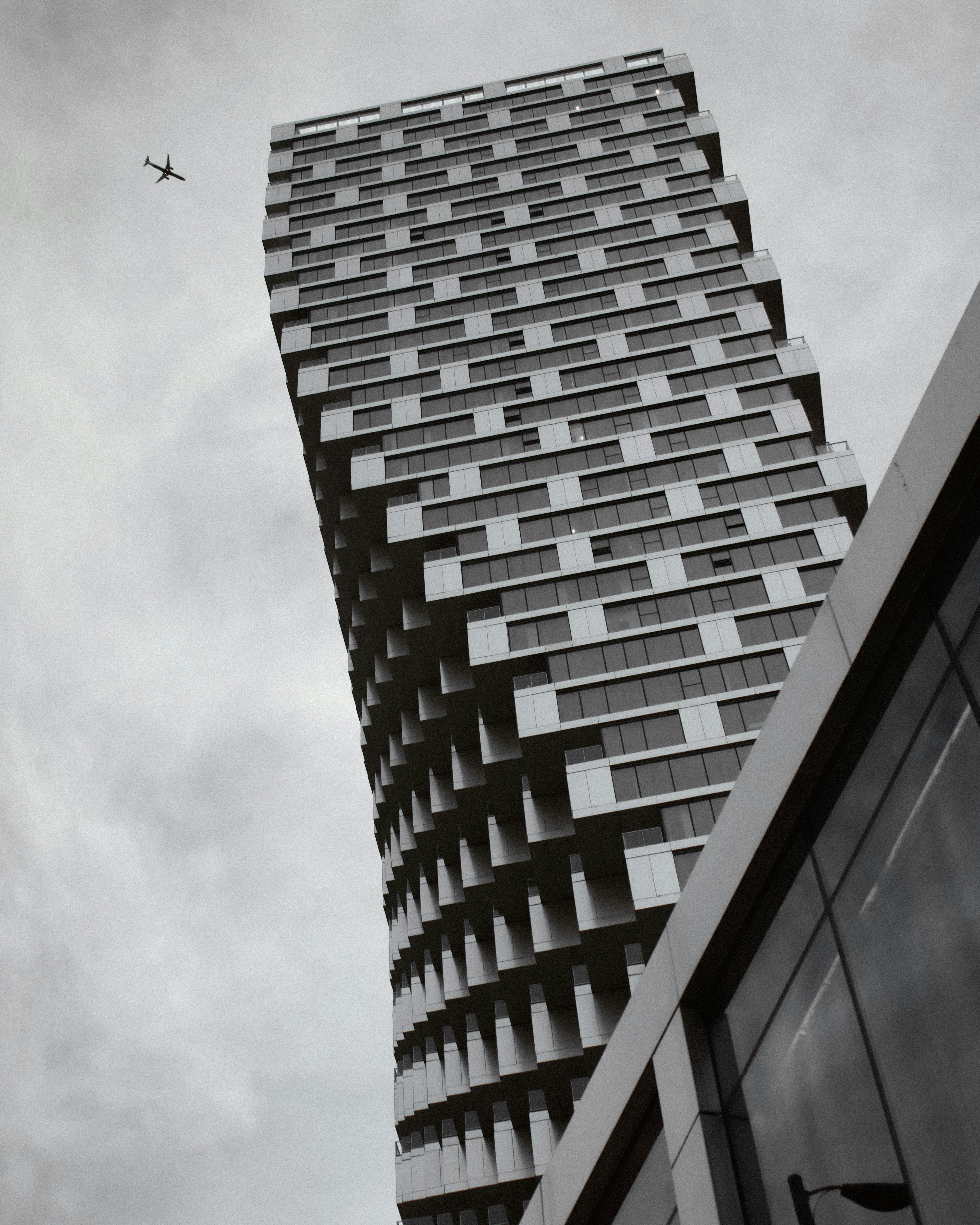 a tall building with a plane flying in the sky