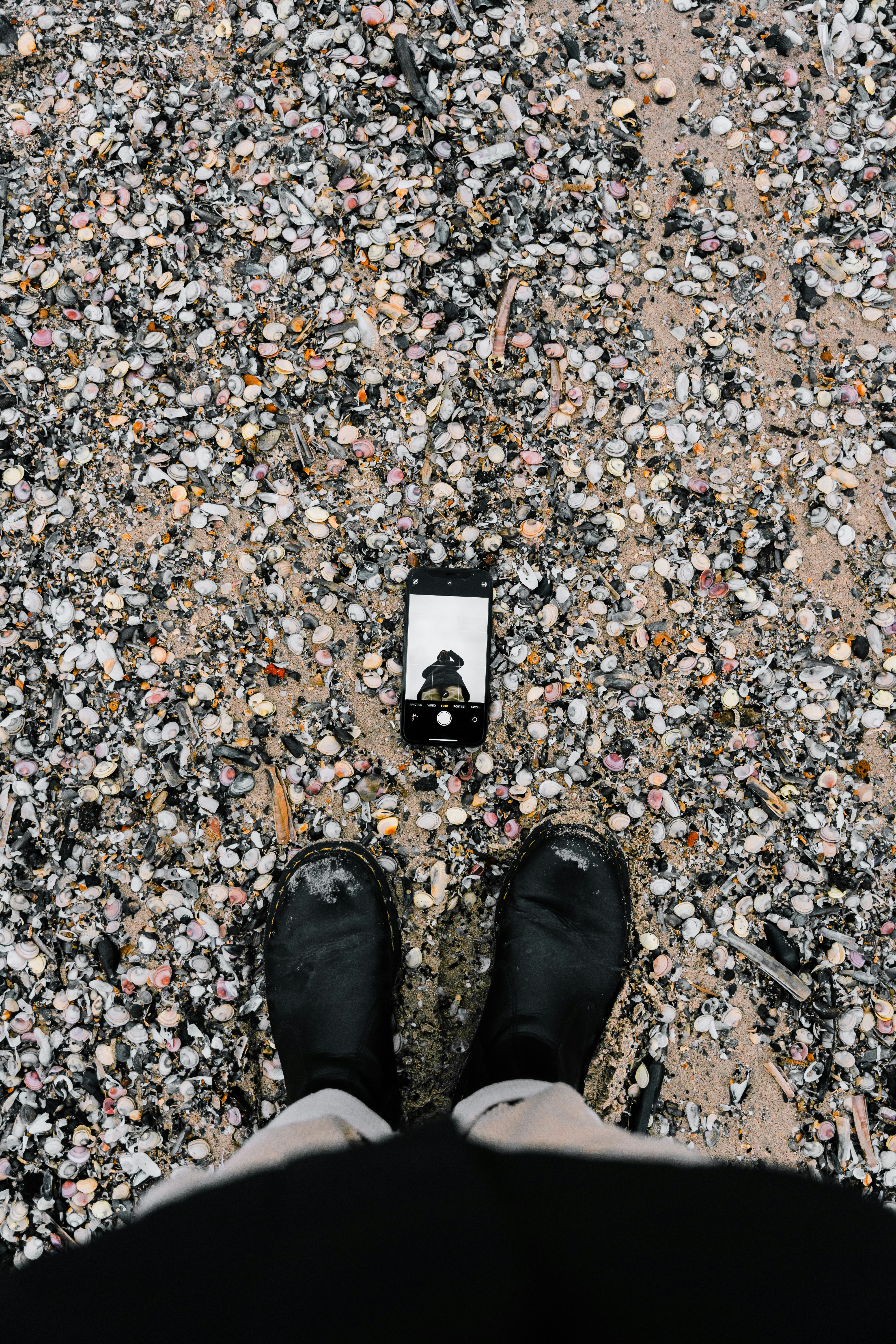 Boots on Pebbled Ground: A Selfie Moment Framed by Bare Feet