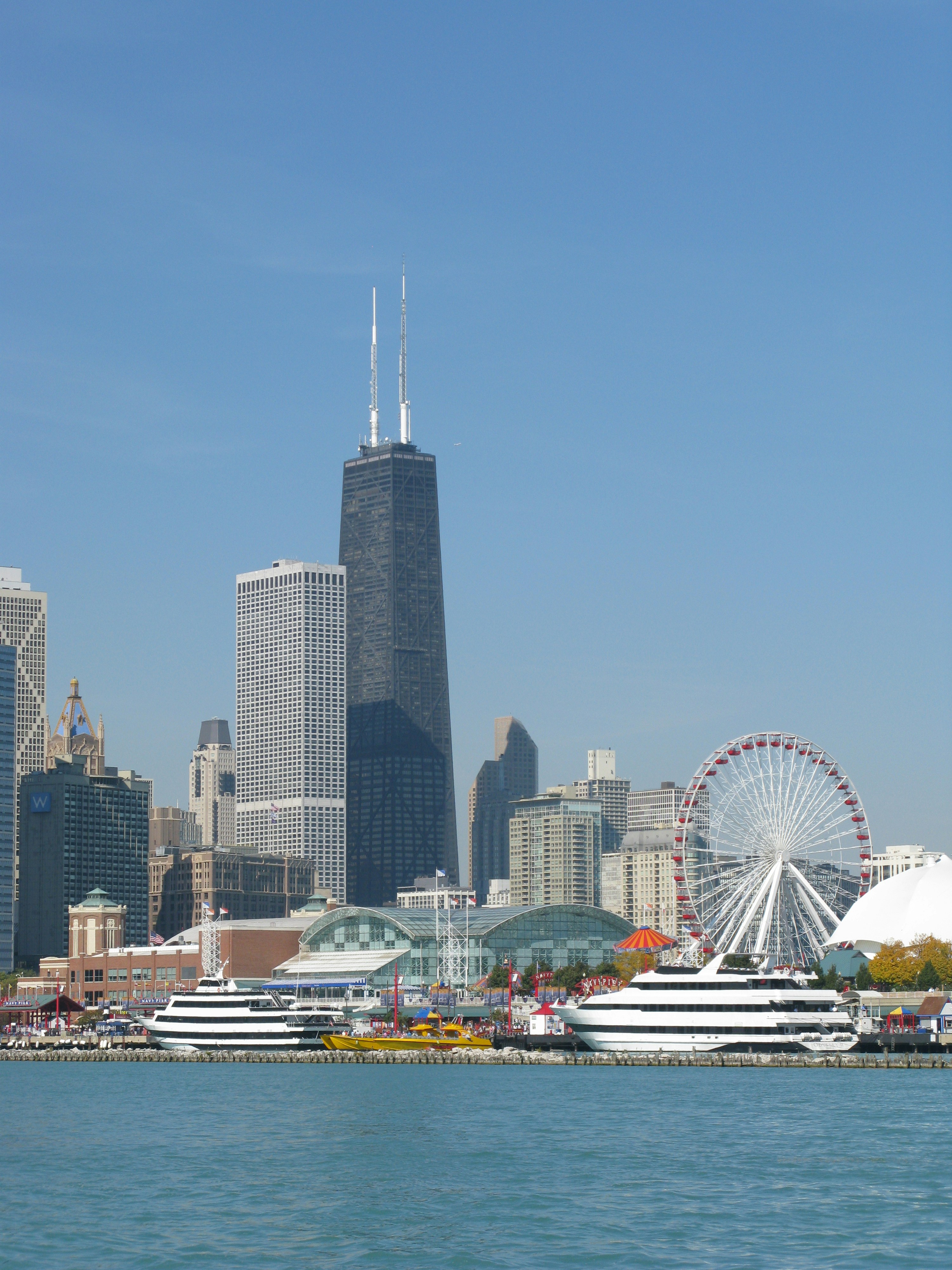 Chicago skyline featuring iconic buildings, a Ferris wheel, and boats along the waterfront.