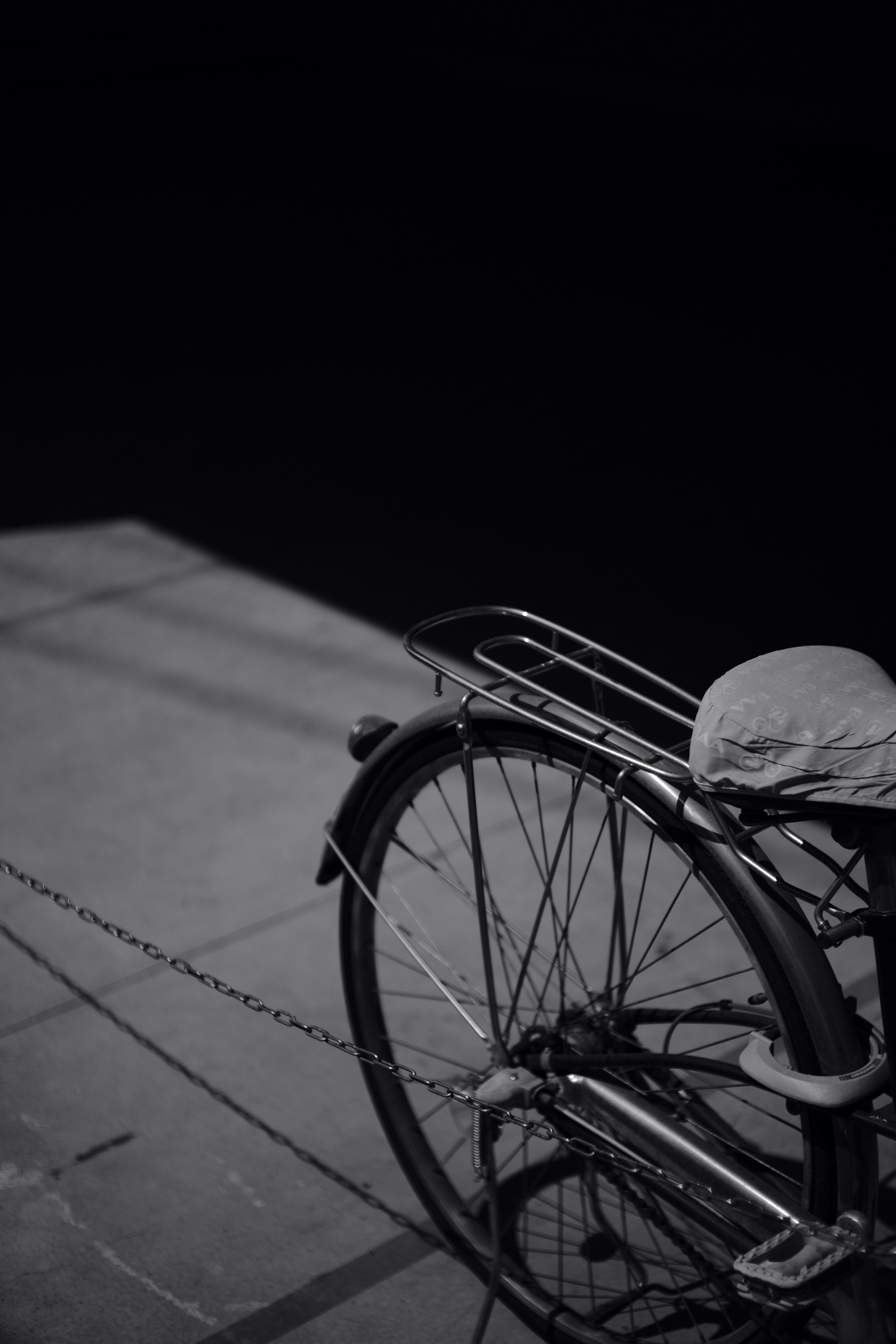 A bicycle chained to a pole on a sidewalk photo – Free Grey Image on ...