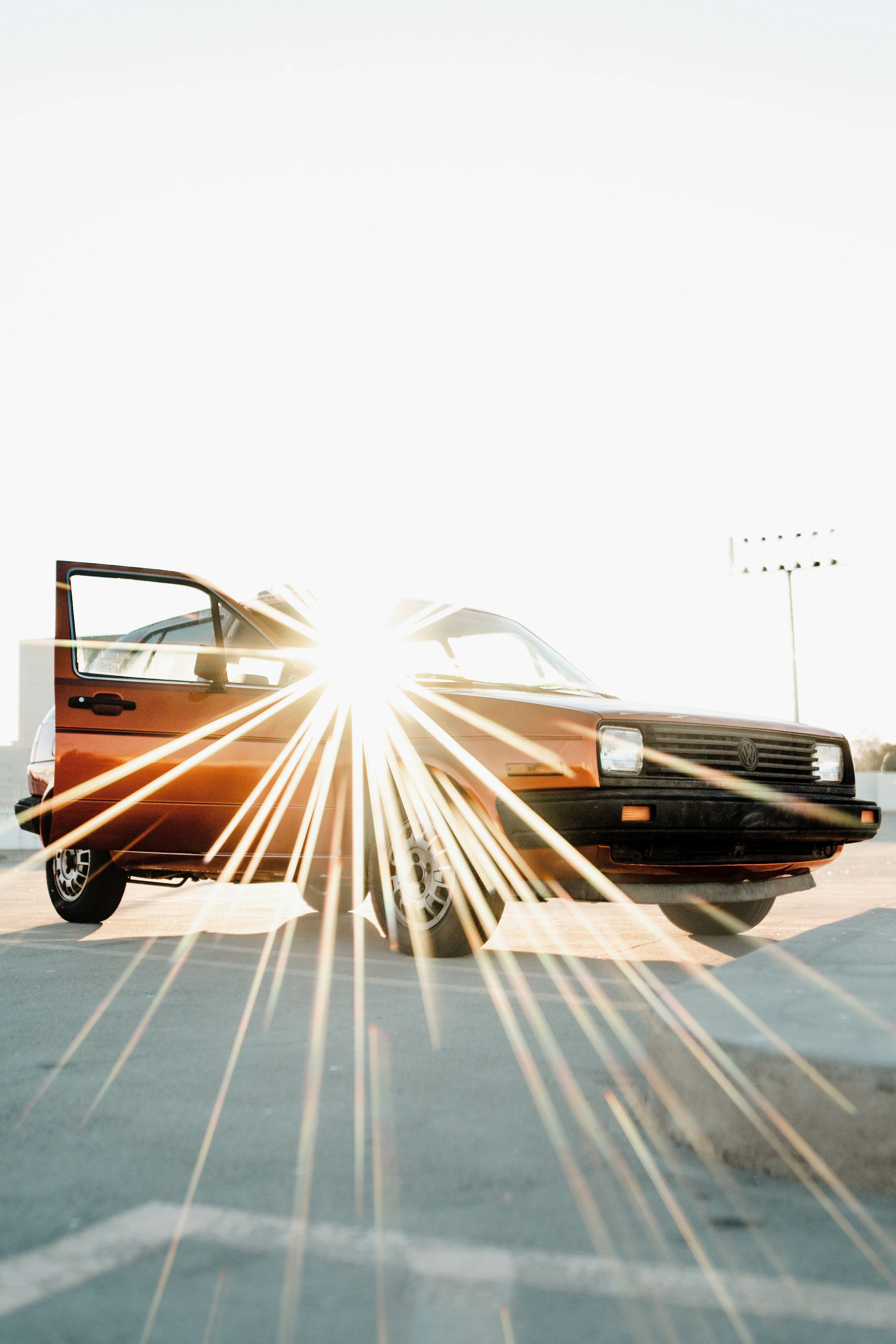 Starburst Sunrise on a Vintage Orange Sedan