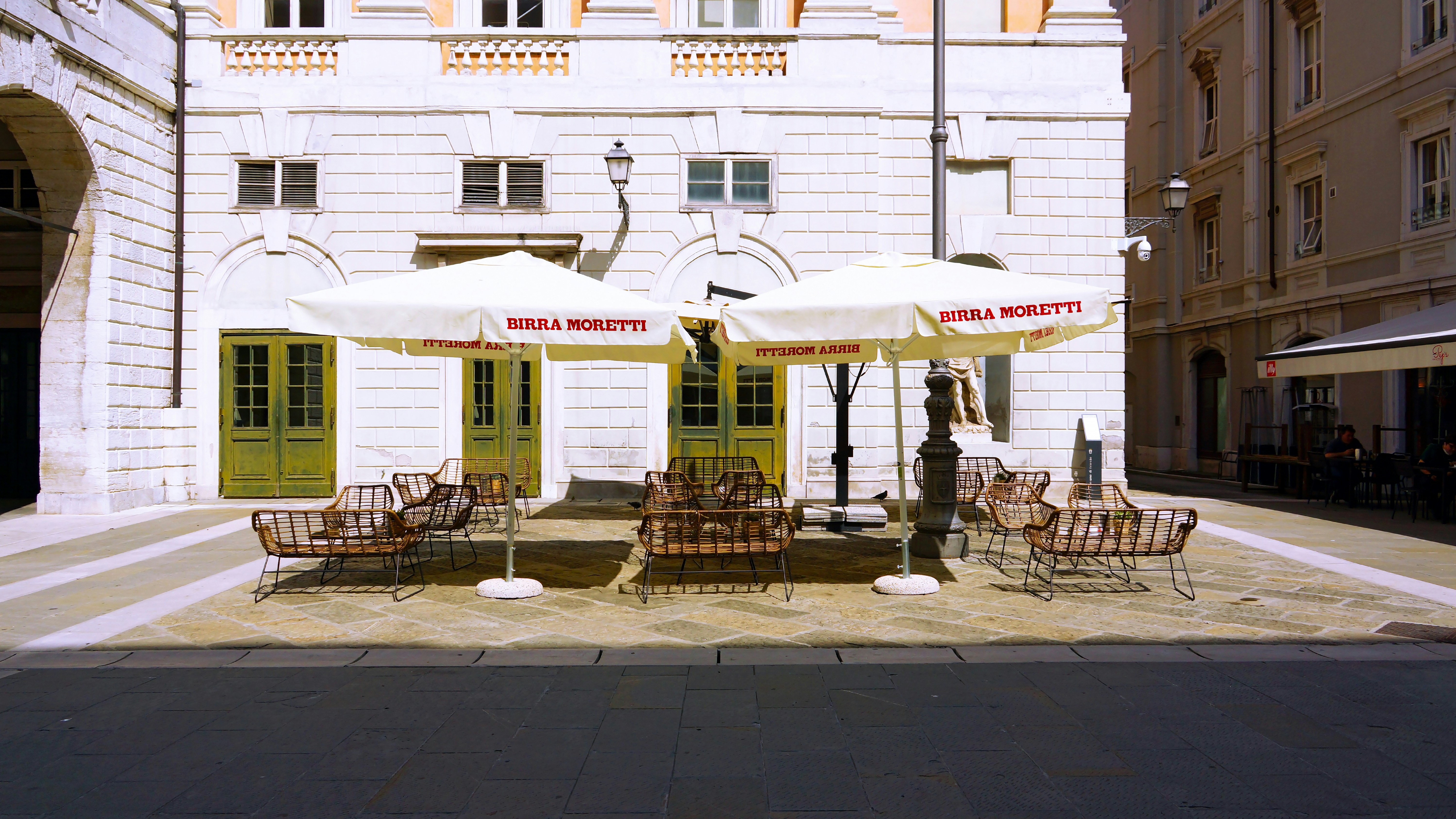 A group of chairs and umbrellas sitting outside of a building photo ...