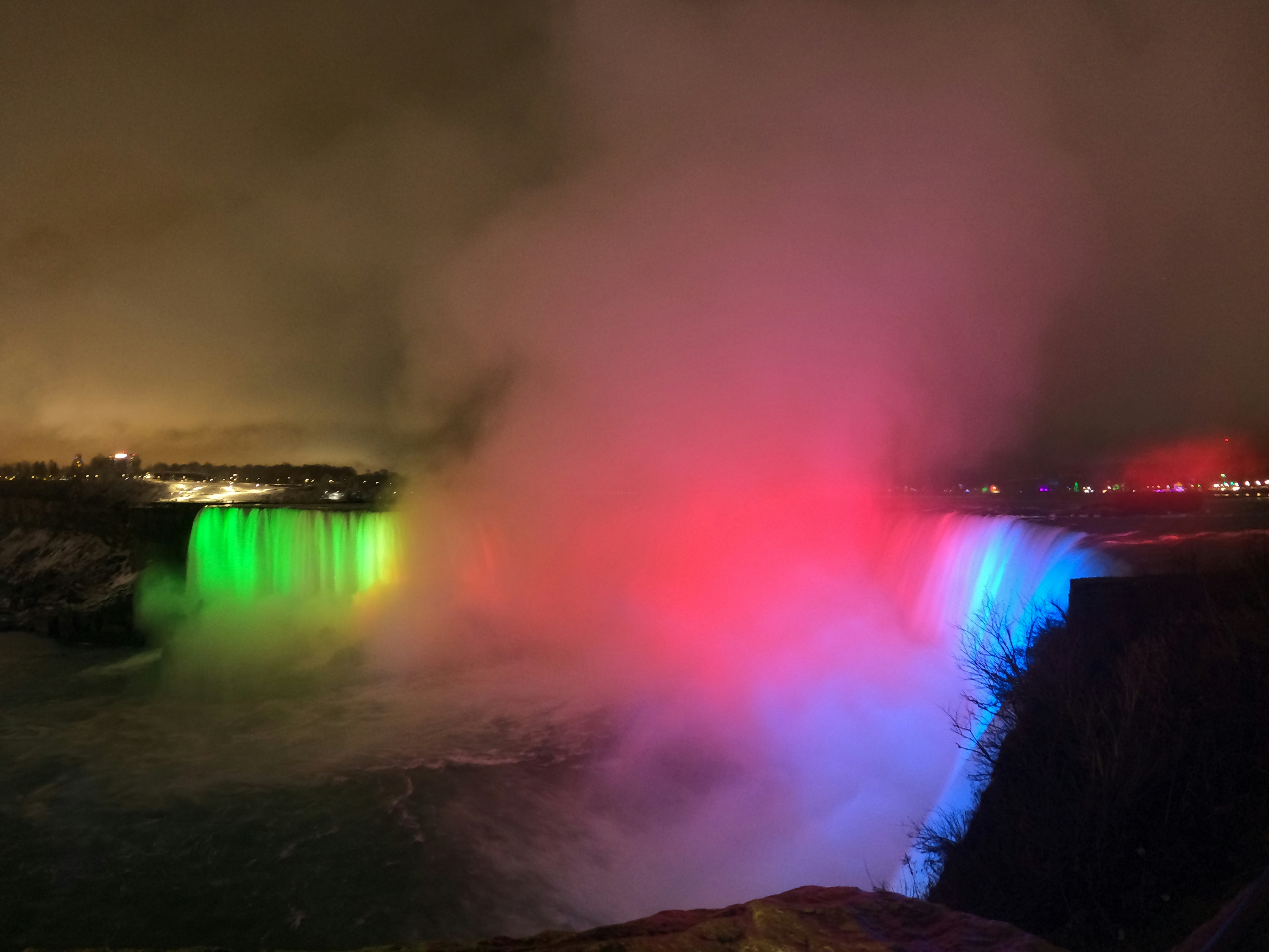 A rainbow colored waterfall in the middle of a body of water photo ...