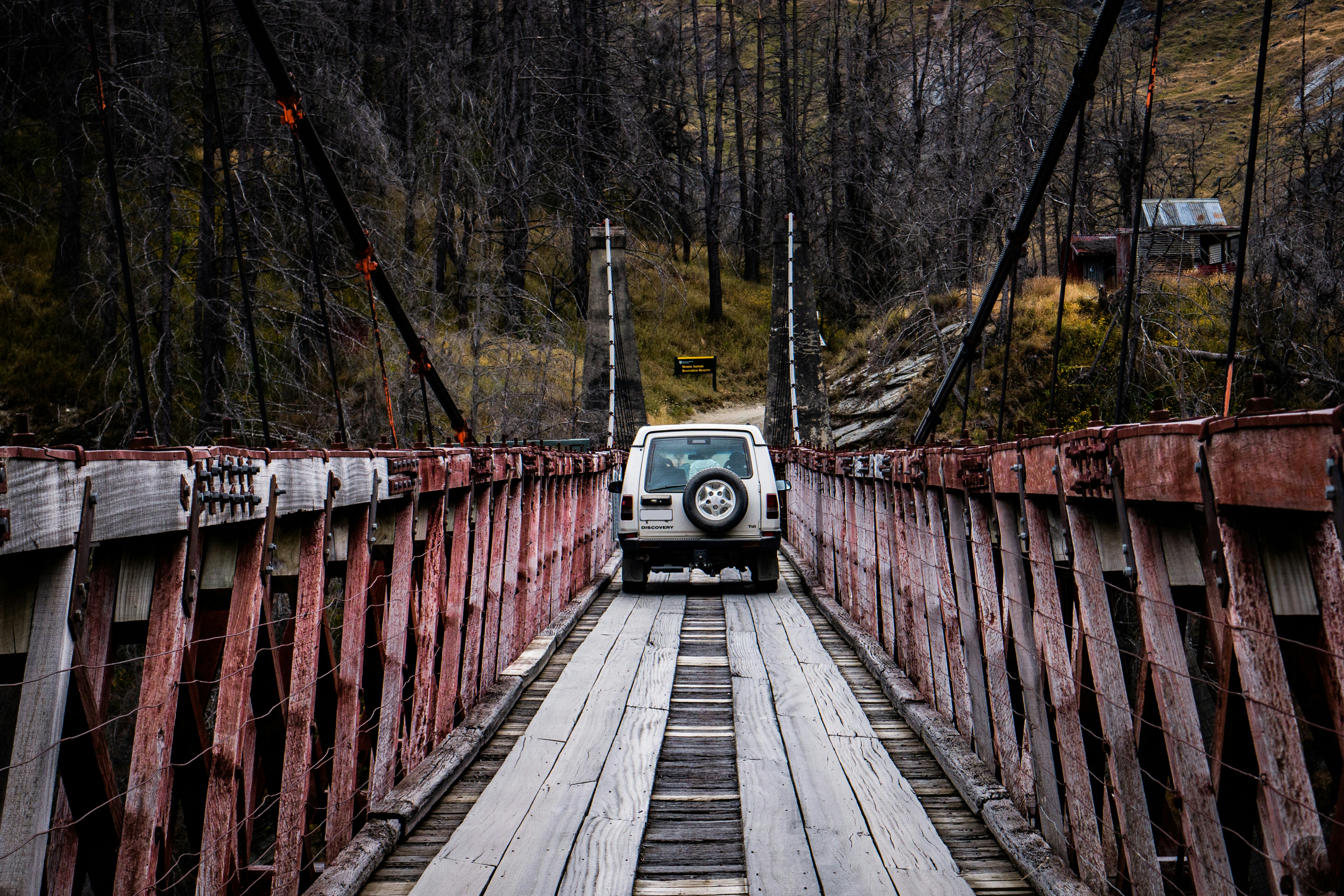 A car driving across a wooden bridge in the woods photo – Free Bridge ...