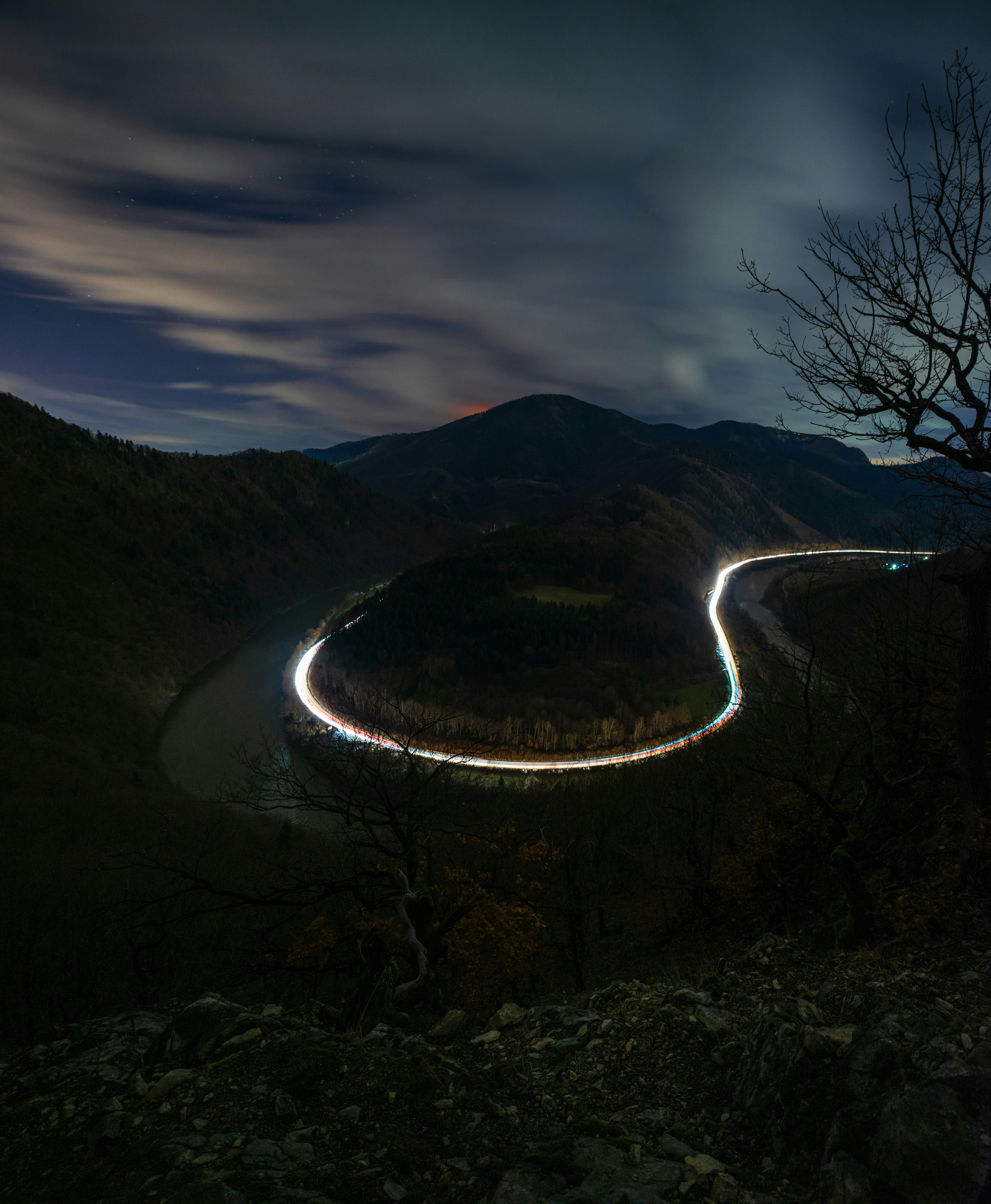 Moonlit Ribbon: A Curving Light Trail Through a Valley