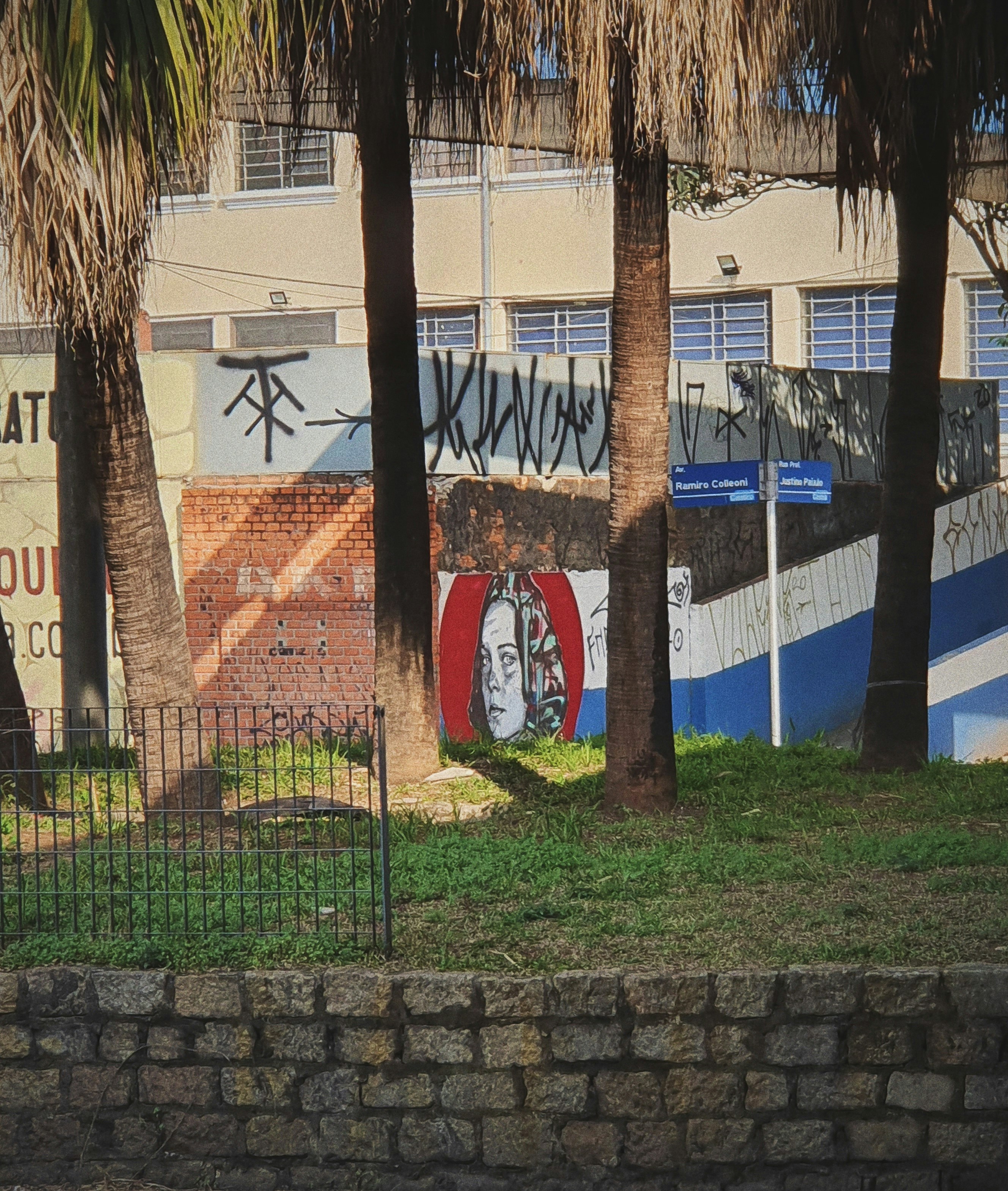 Graffiti Wall with Circular Portrait tucked among trees