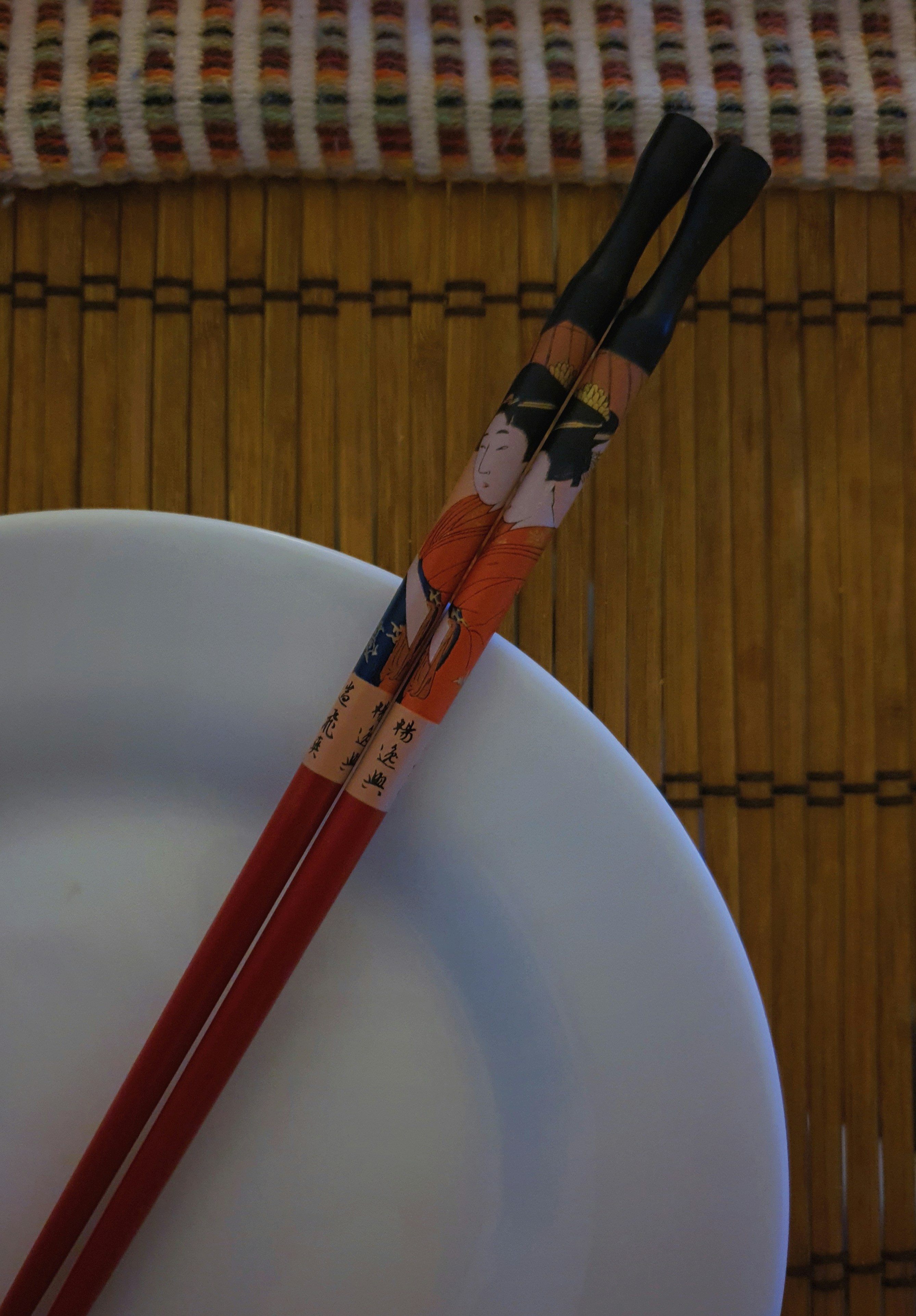 two chopsticks sitting on top of a white plate