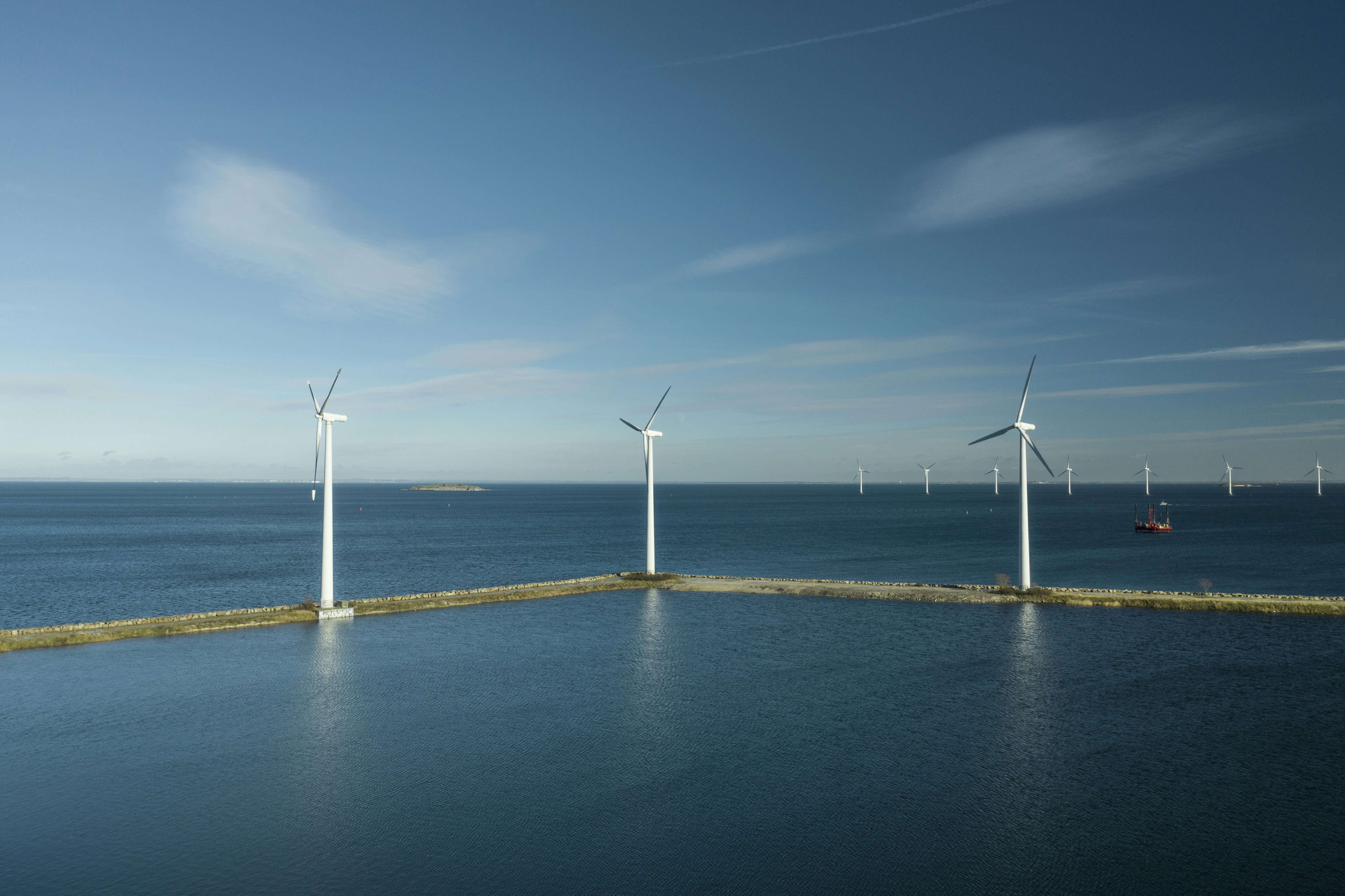 A row of wind turbines next to a body of water photo – Free Copenhagen ...
