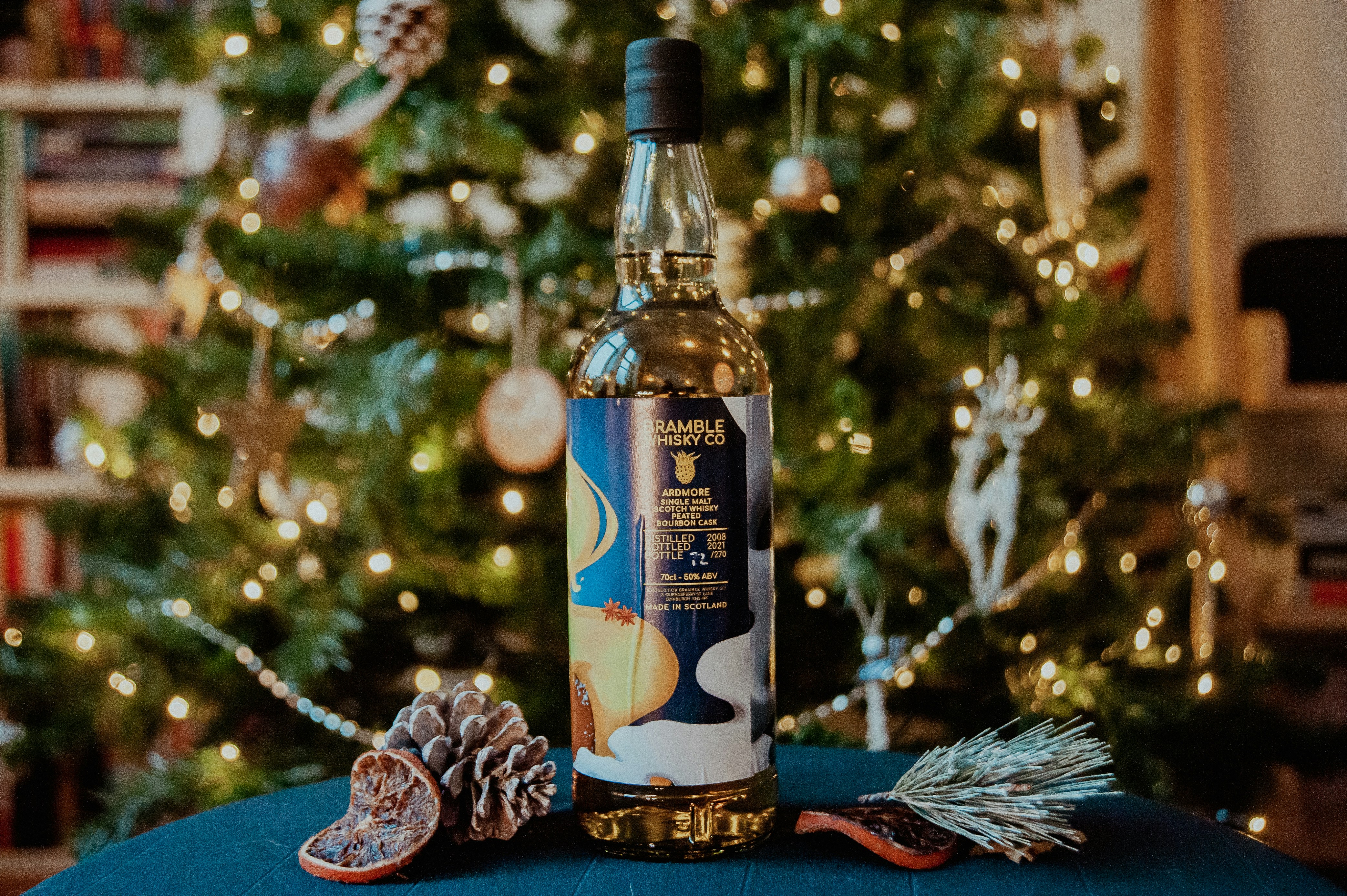 A bottle of alcohol next to a christmas tree photo – Free Product ...