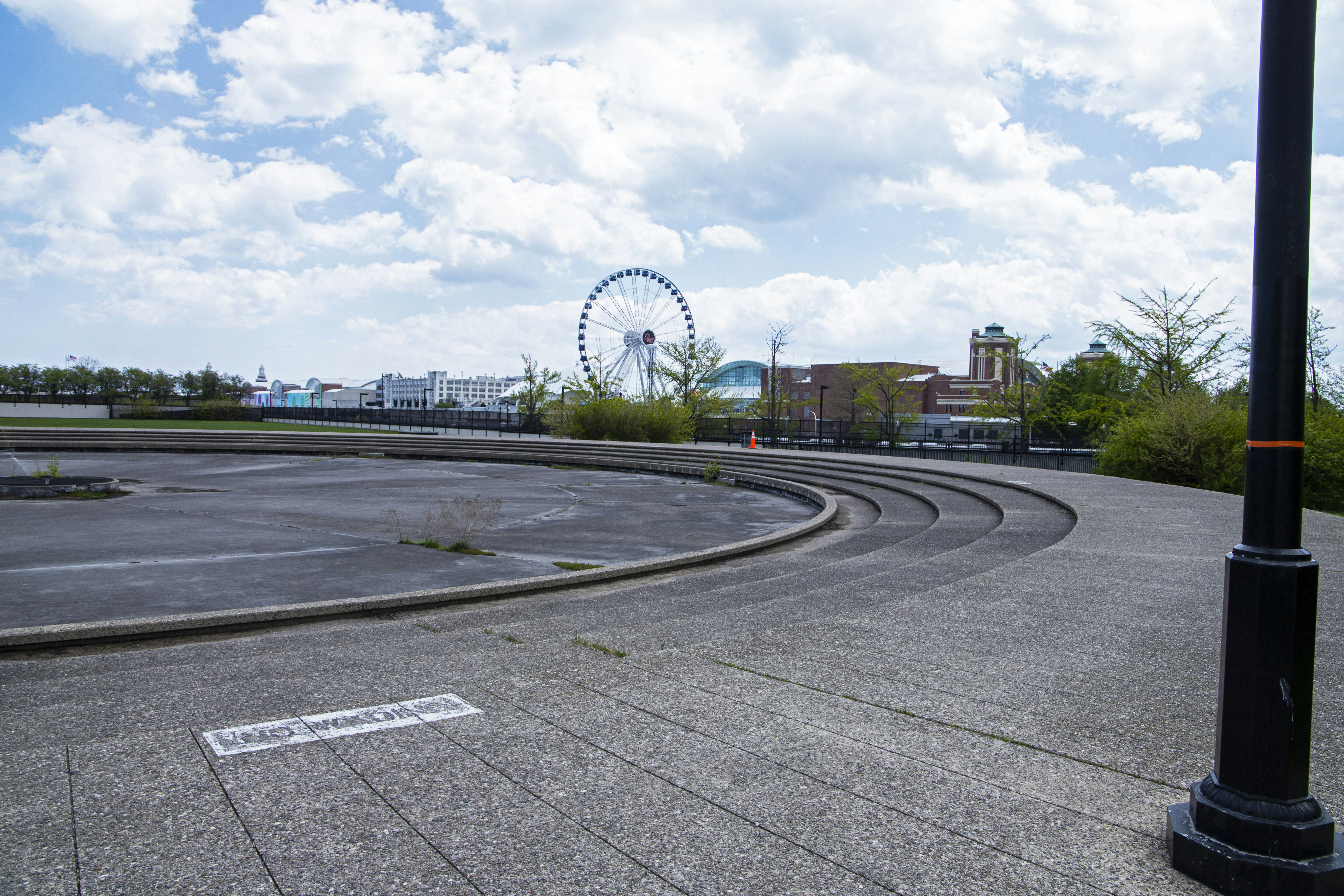 Circling Echoes: Ferris Wheel Over a Quiet Waterfront Plaza