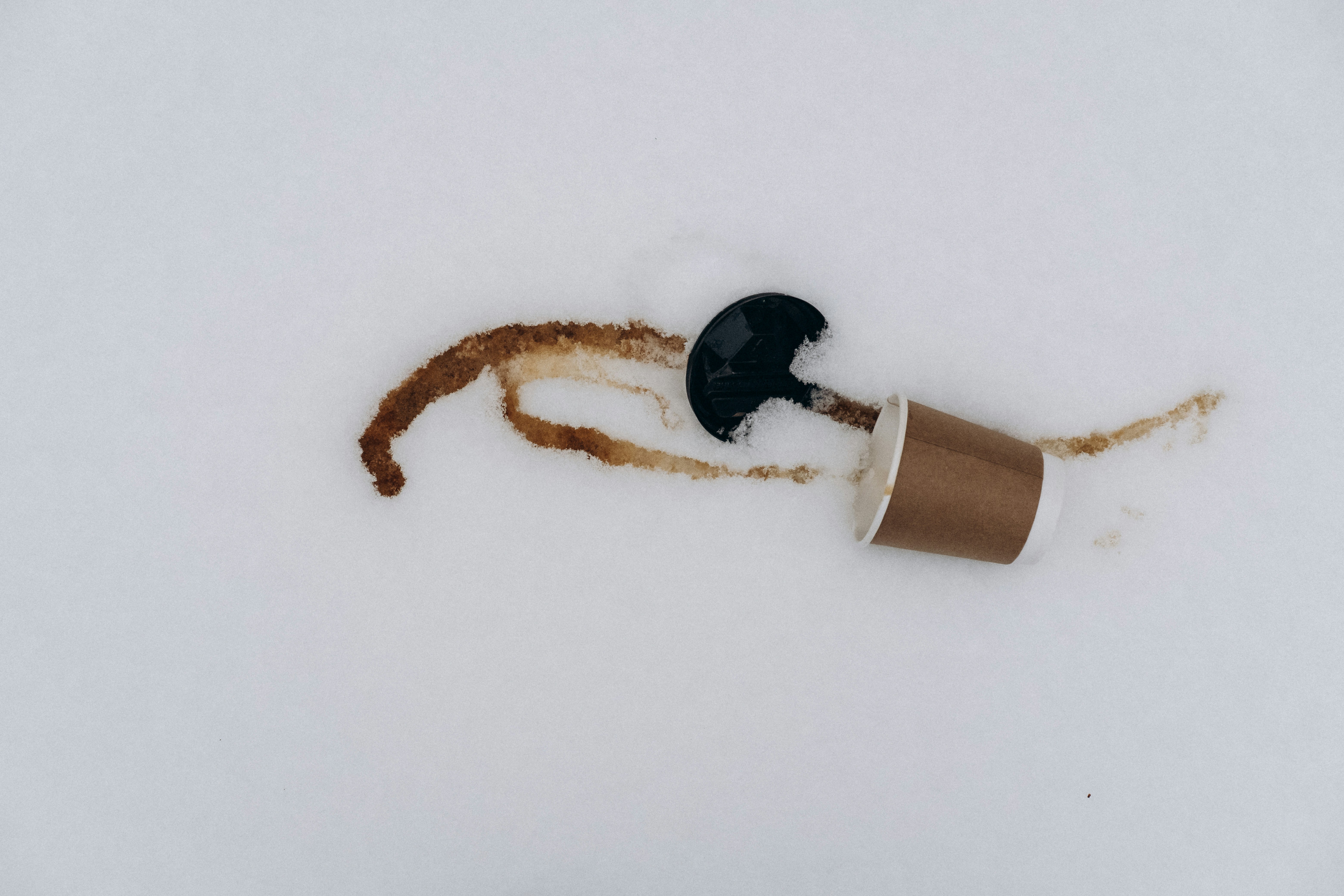 Snowy Scene with a Spent Coffee Cup and Constellation of Tracks