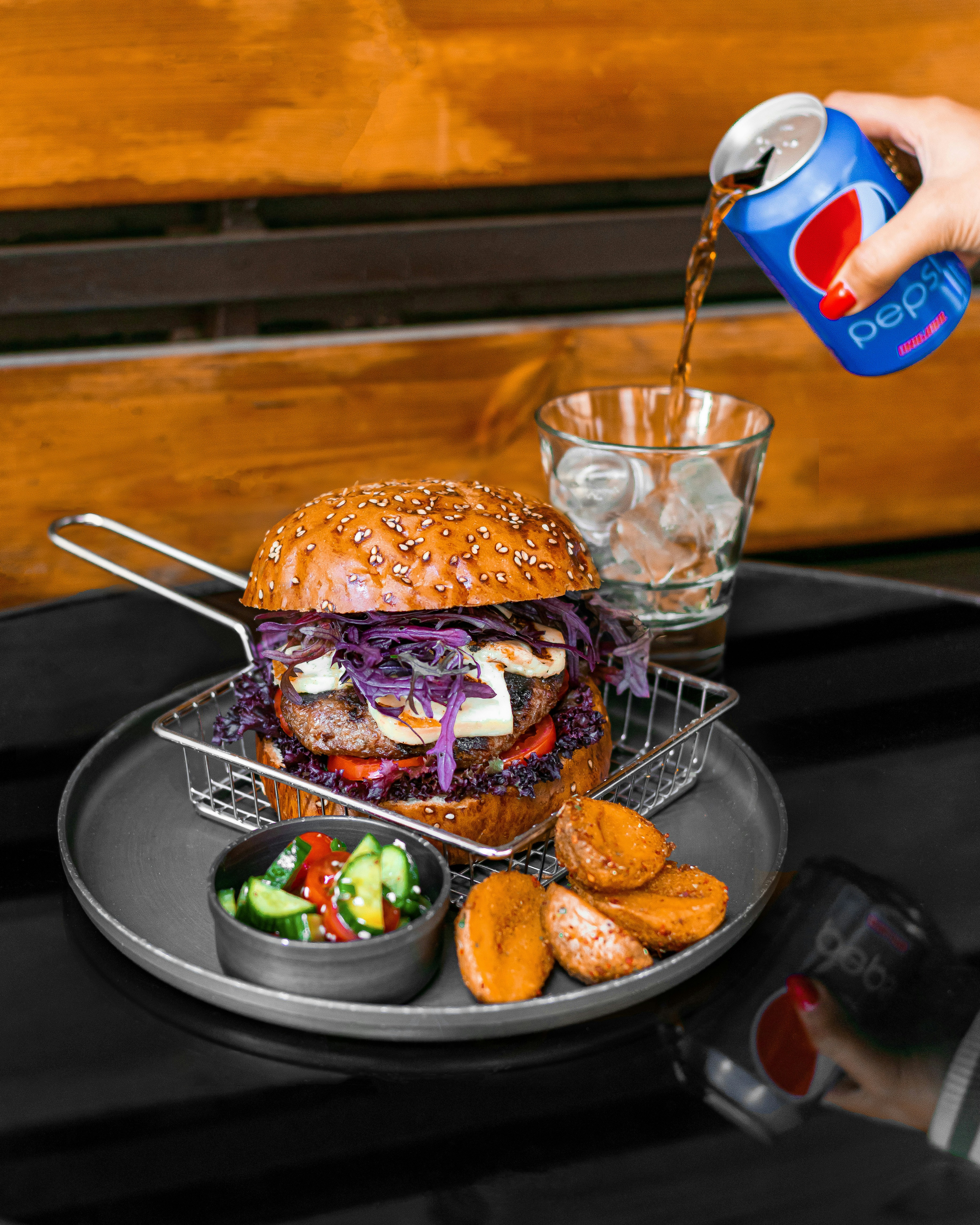 Pouring Cola and Crunch: A Gourmet Burger Moment