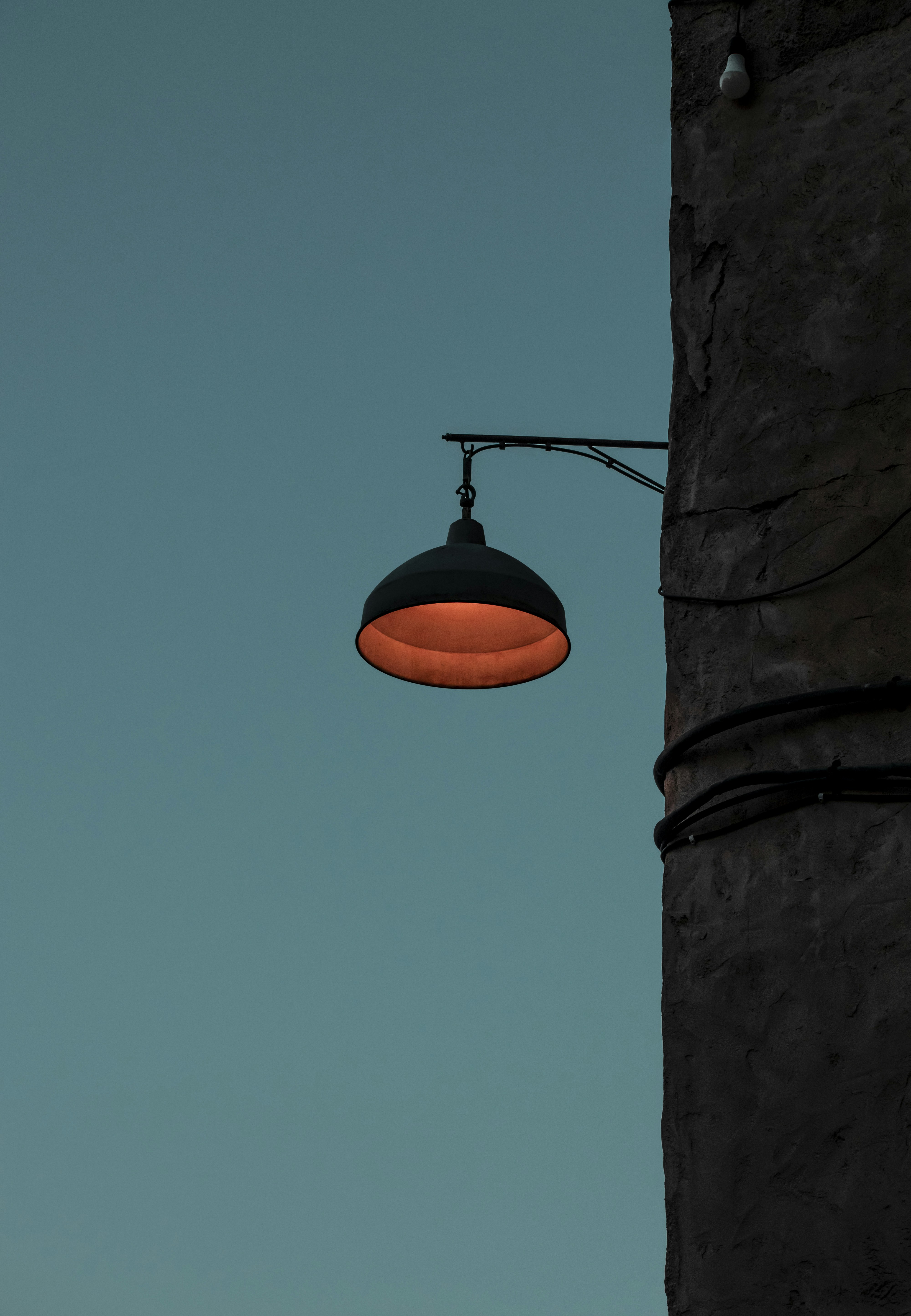 an orange light hanging from the side of a building