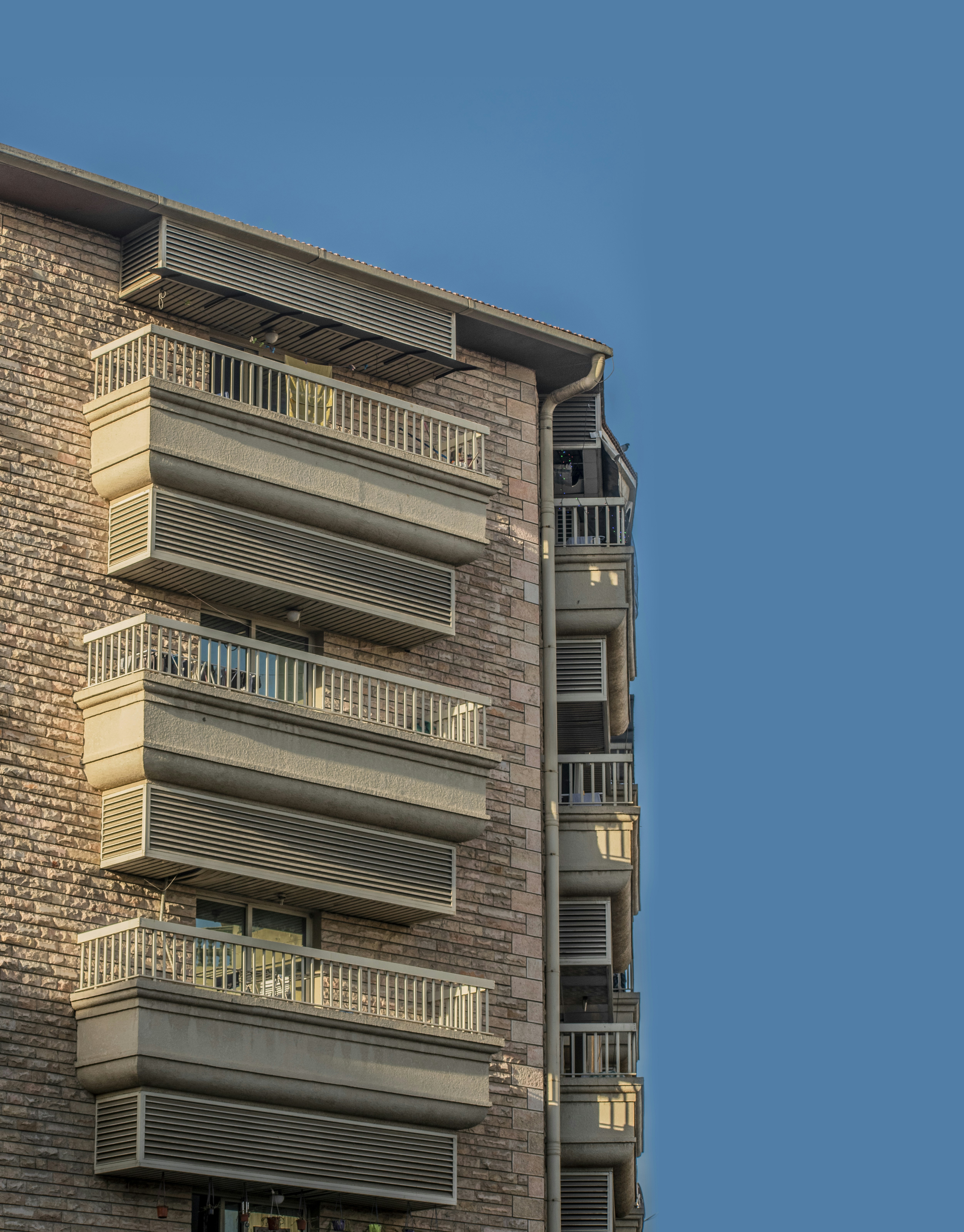 A tall brick building with balconies and balconies photo – Free Sharjah ...
