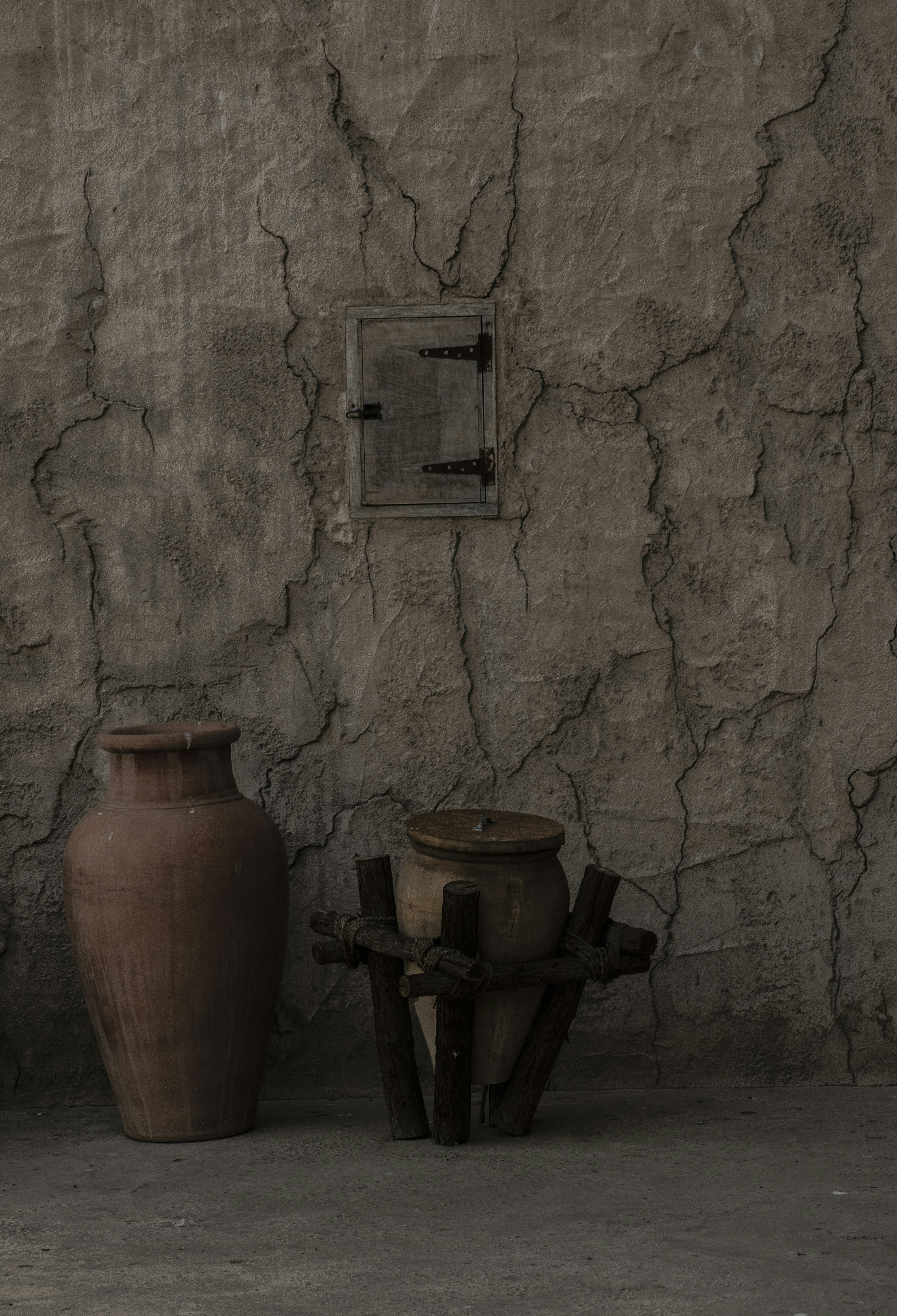 Two traditional clay pots beside a weathered wall, showcasing rustic craftsmanship and cultural identity.