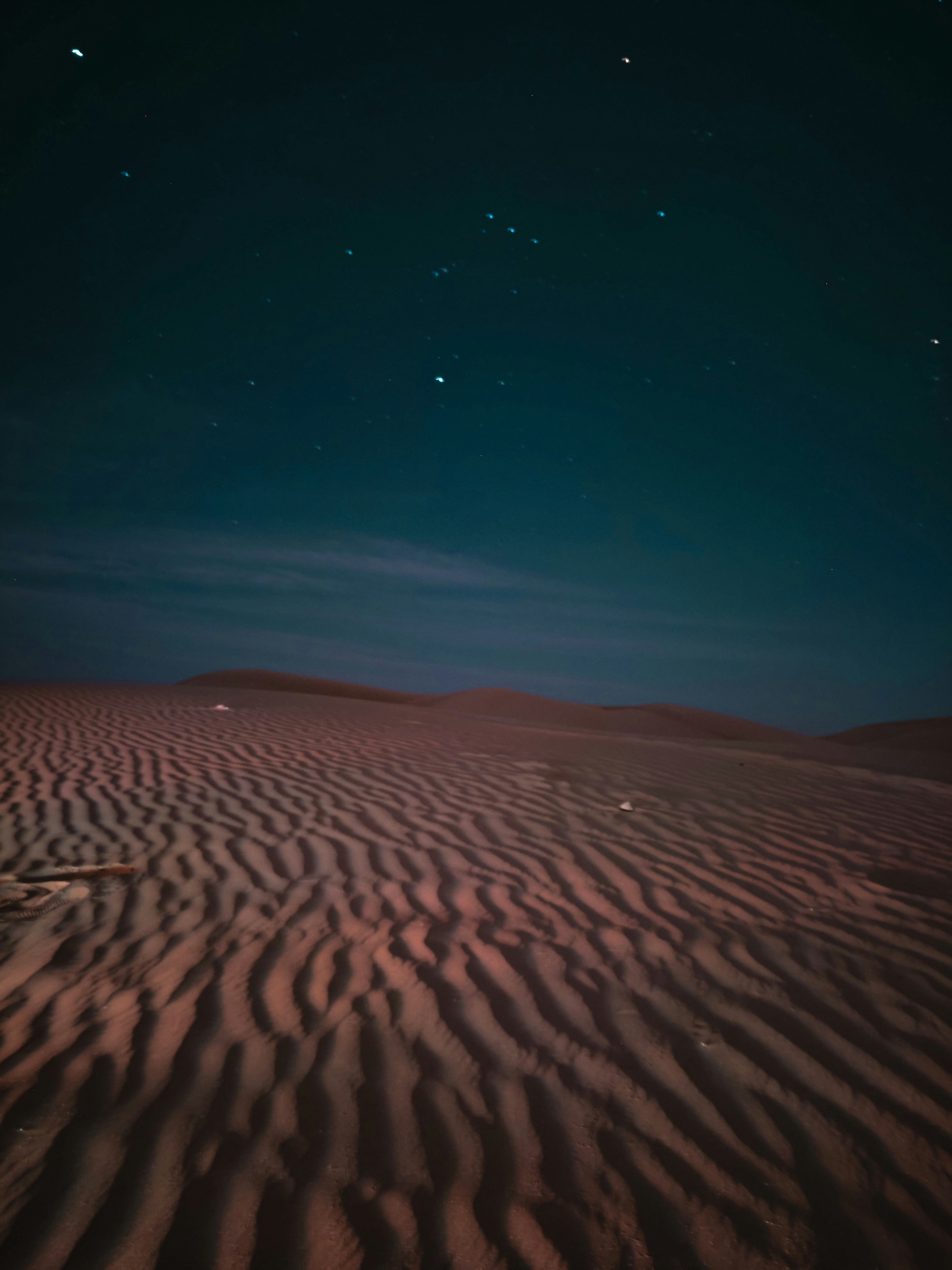 a night sky with stars above a desert