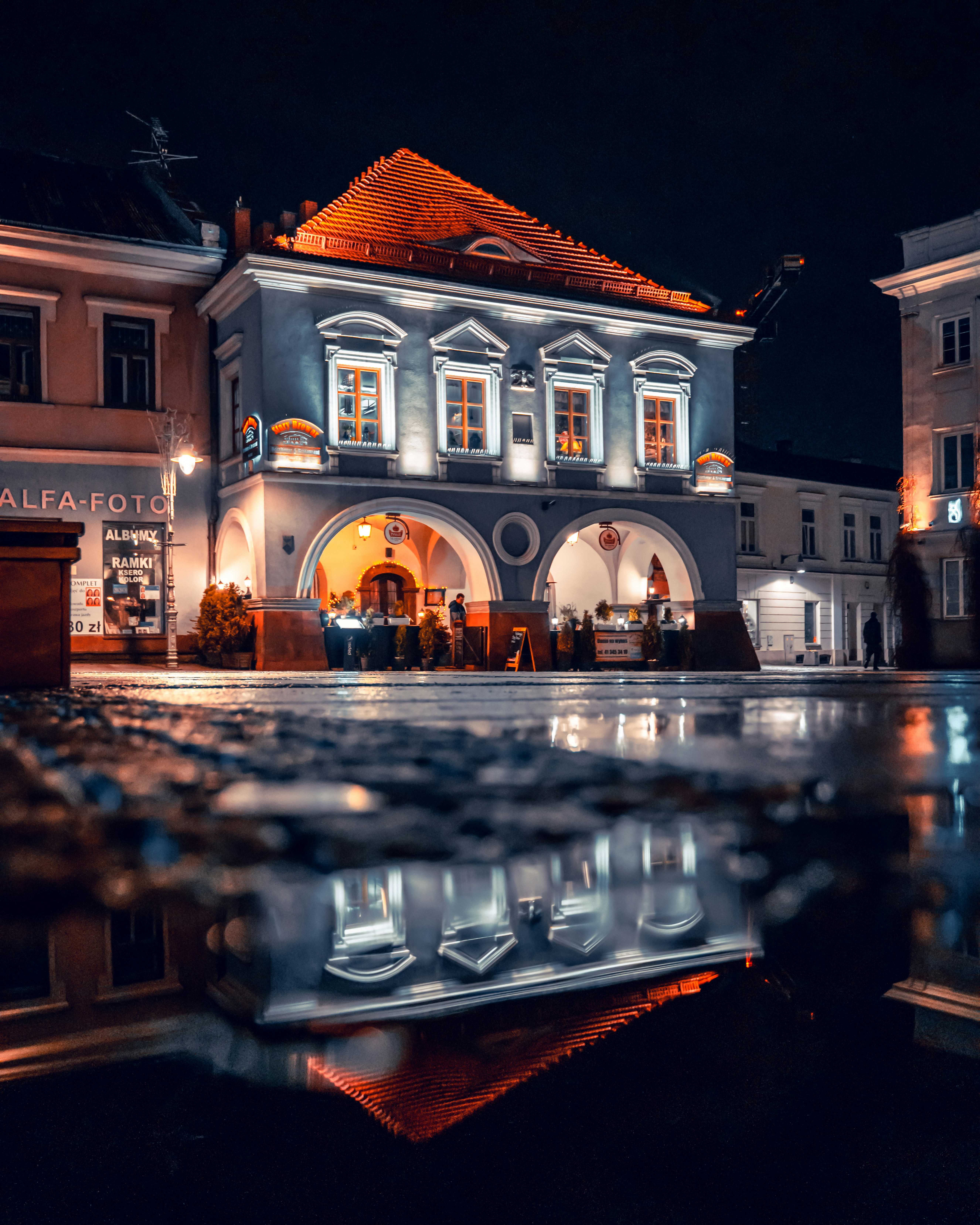 a reflection of a building in a puddle of water