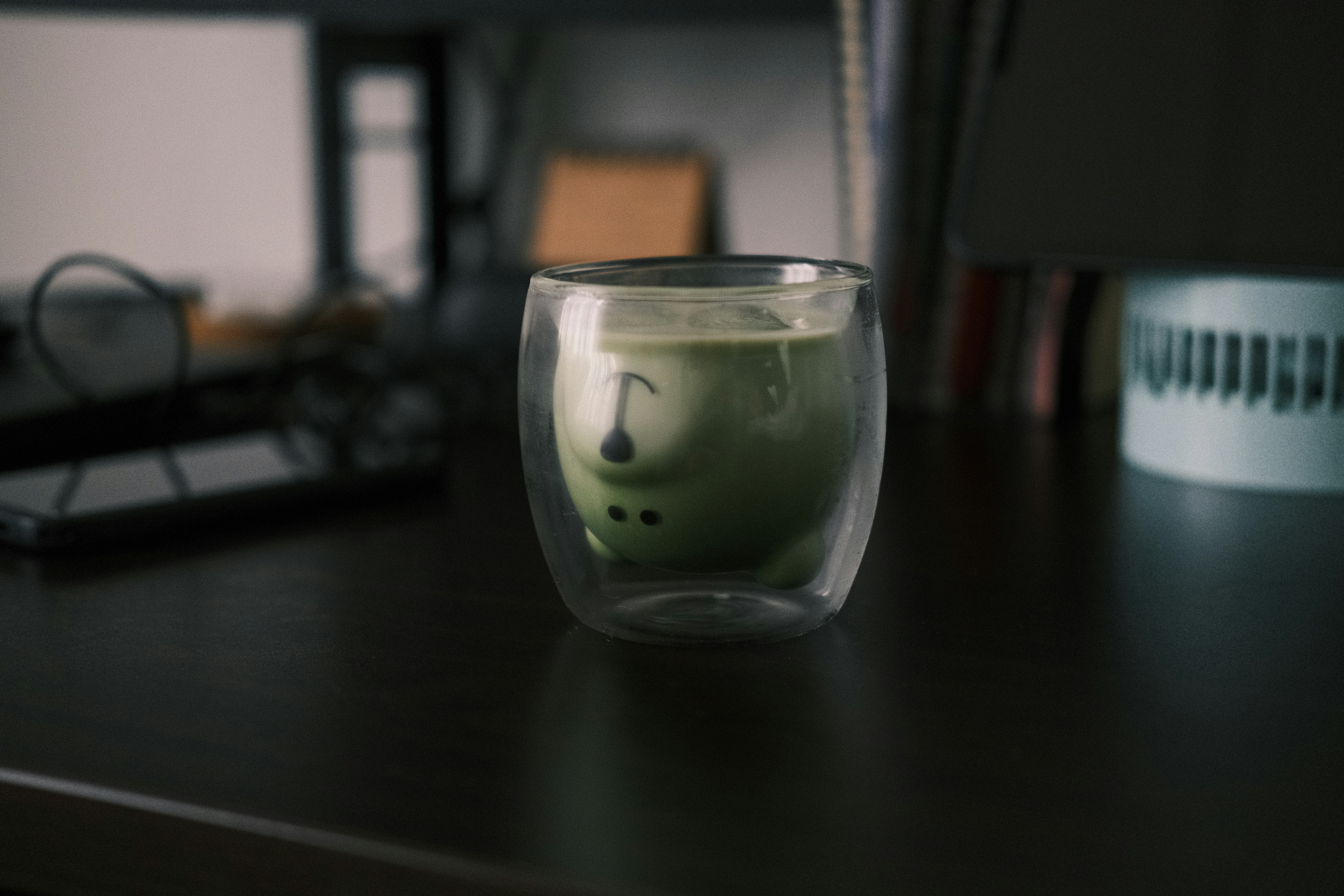 Quiet Focus: A Glass with a Hidden Face on a Dim Desk