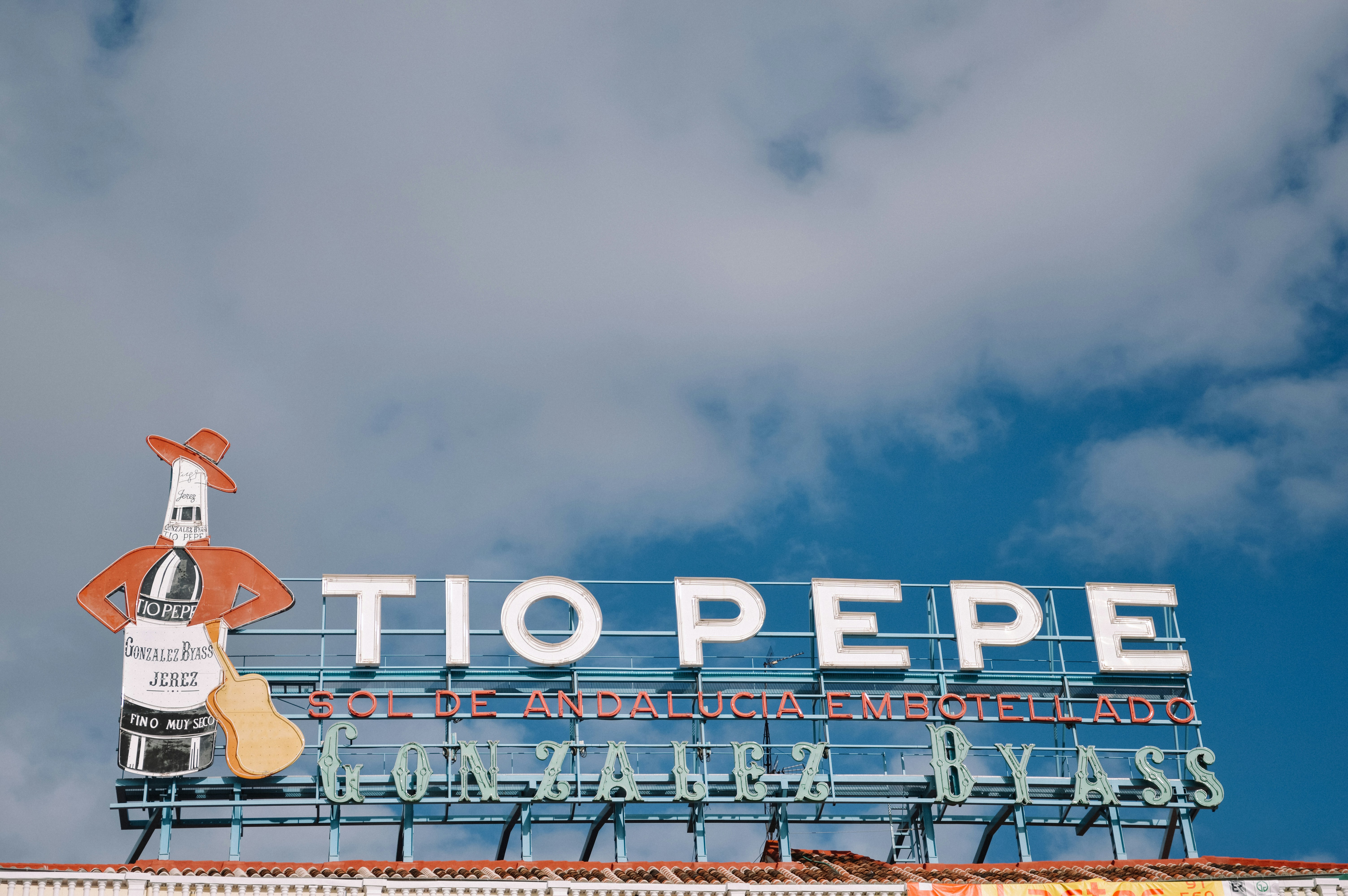 Tio Pepe Rooftop Sign: Guitarman Under a Bright Andalusian Sky