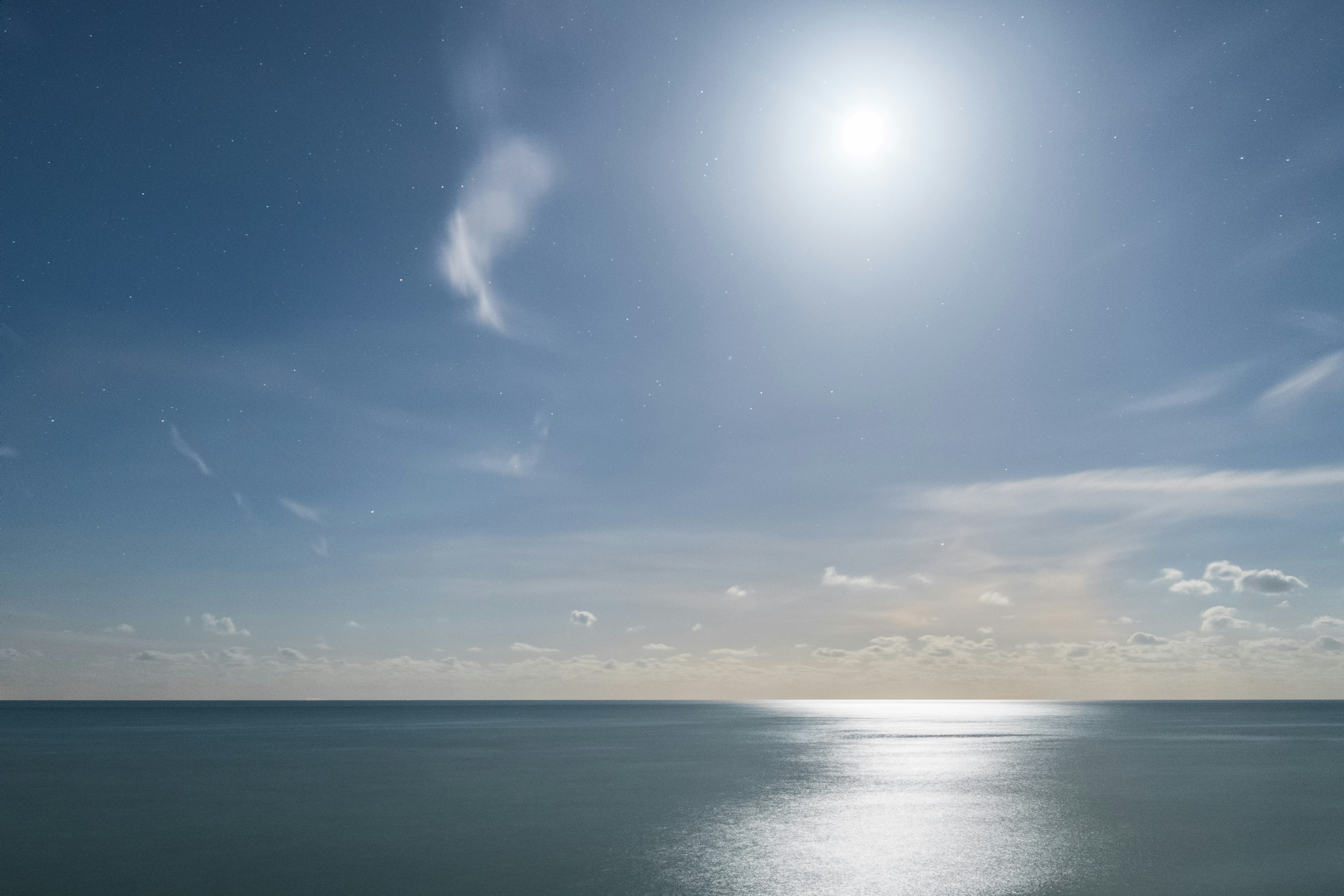 Sunlit Quiet: A Glassy Sea Reflecting a Sky of Silence
