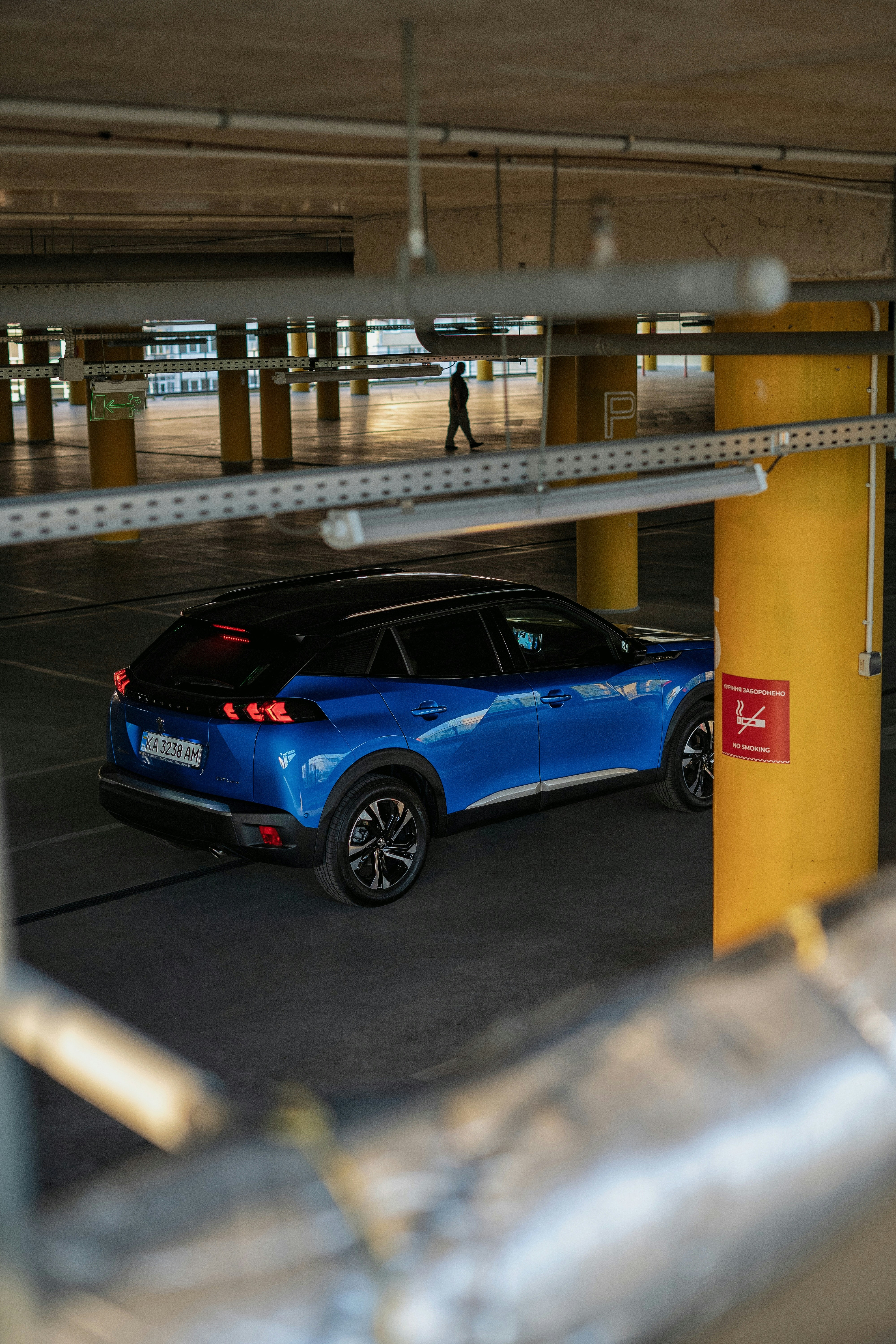 Blue SUV Amid Concrete Pillars in an Urban Parking Garage