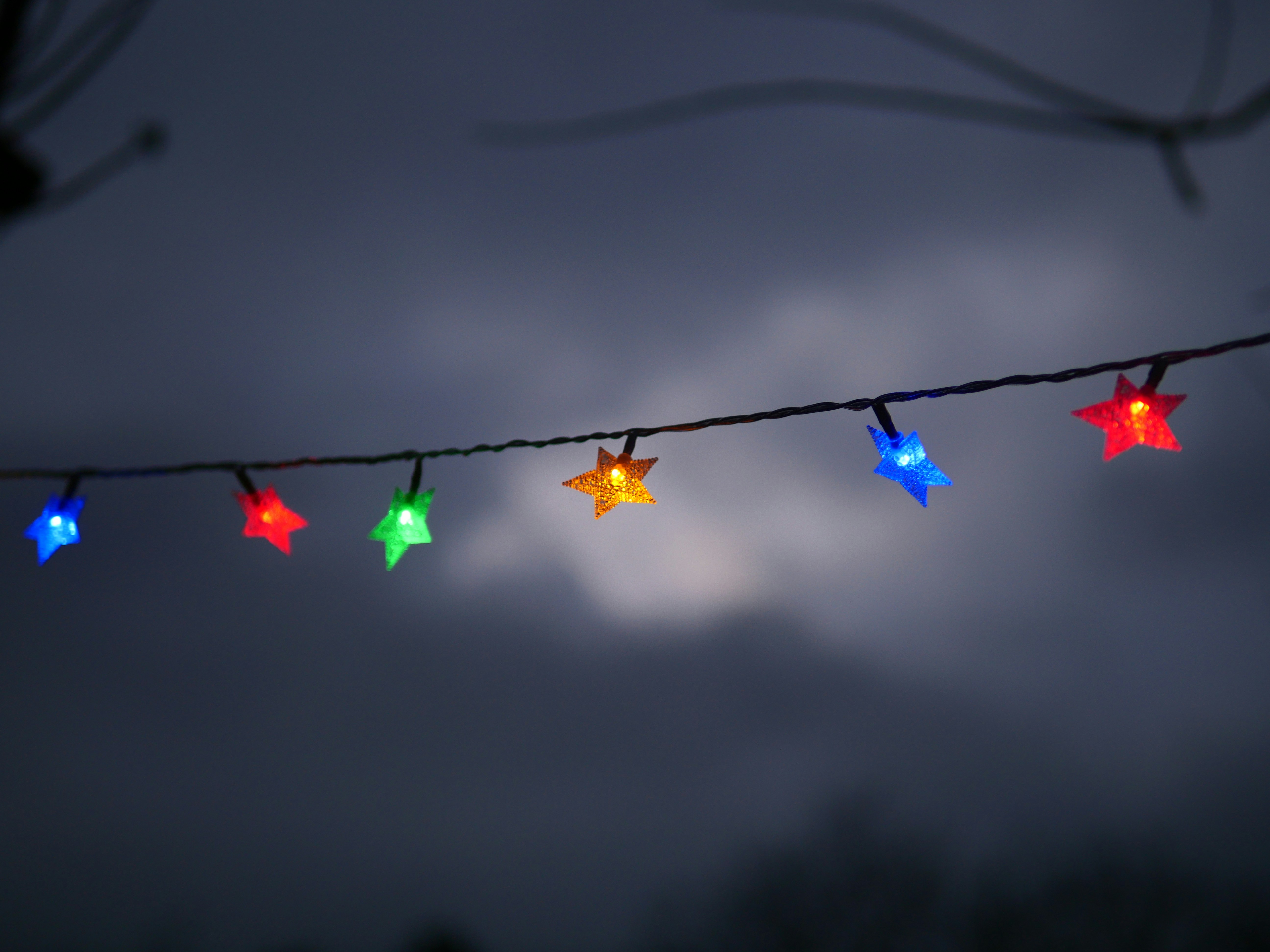 Colorful star-shaped lights strung against a dark, cloudy backdrop, creating a whimsical atmosphere.