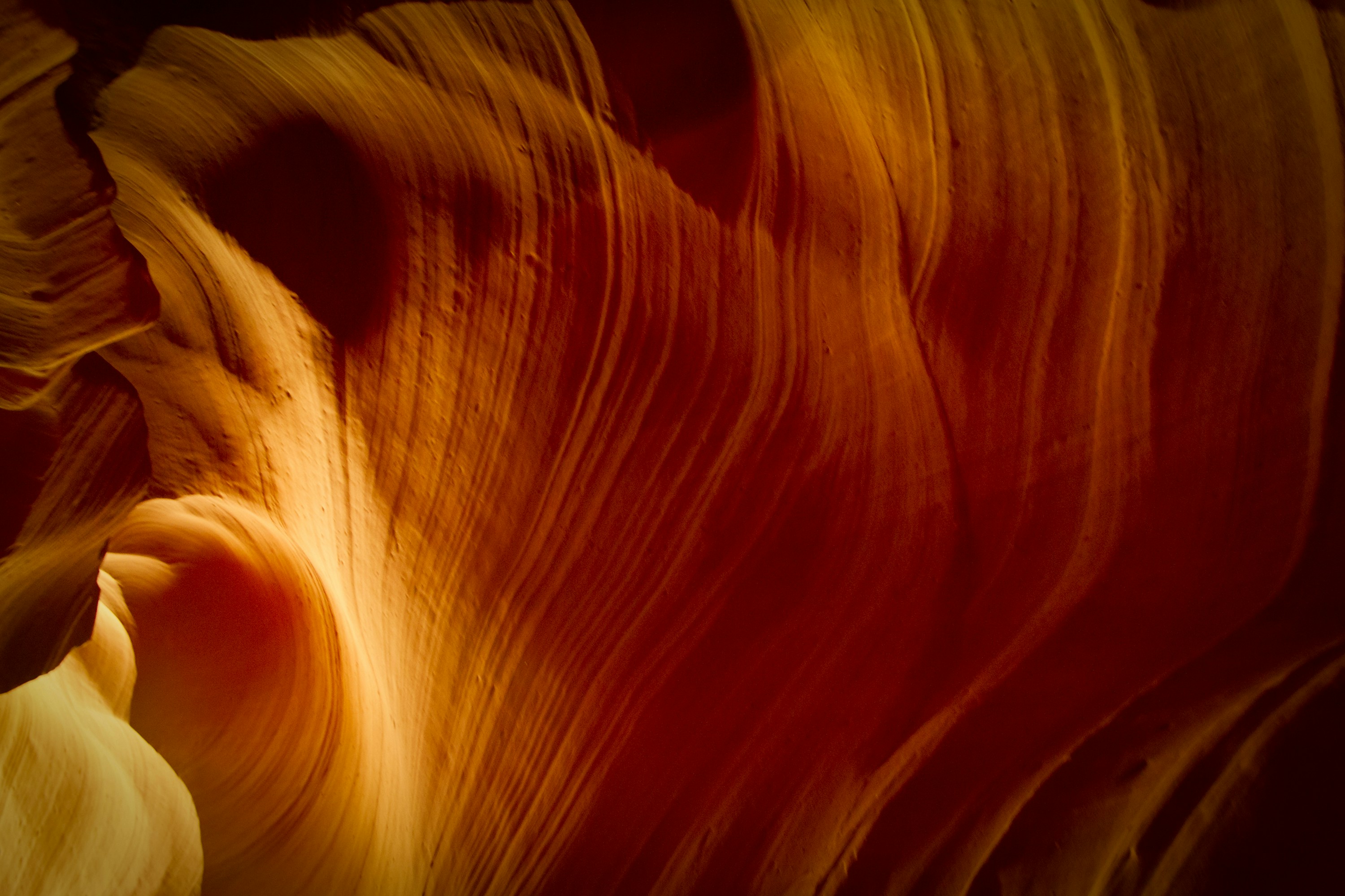 Curved sandstone layers bathed in warm golden light.