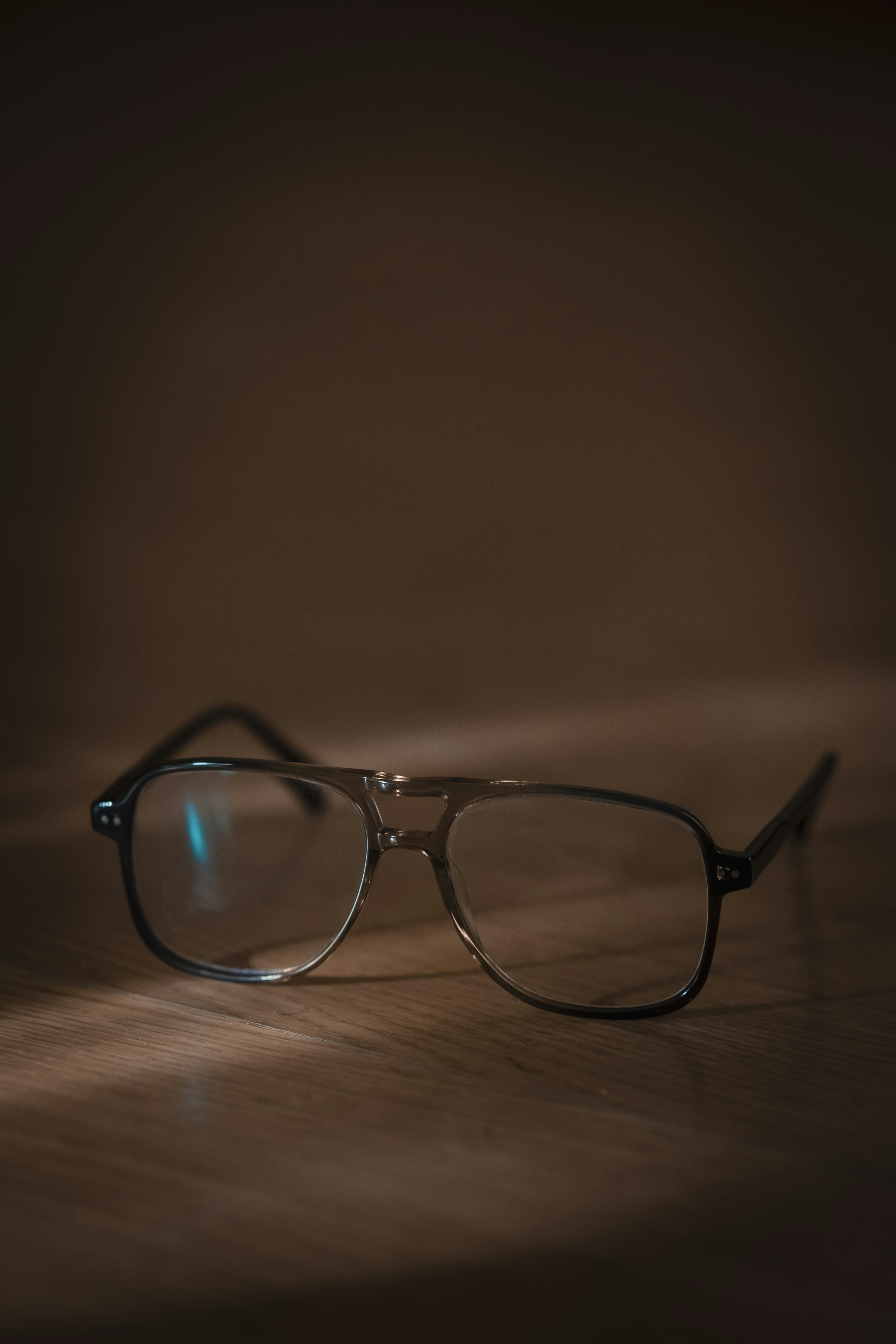 a pair of glasses sitting on top of a wooden table