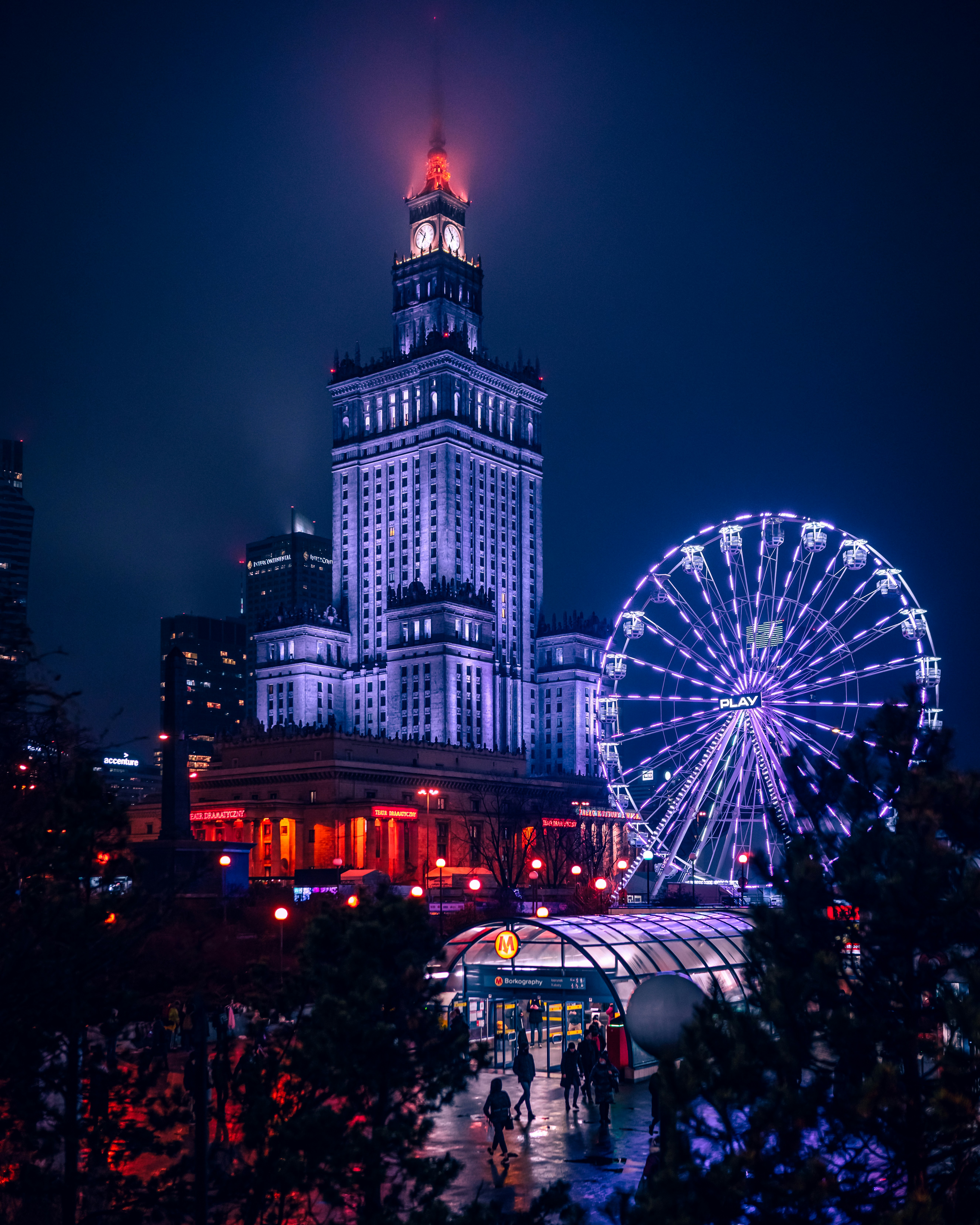 Nightfront Over Warsaw: The Palace of Culture Tower Beside a Neon Ferris Wheel