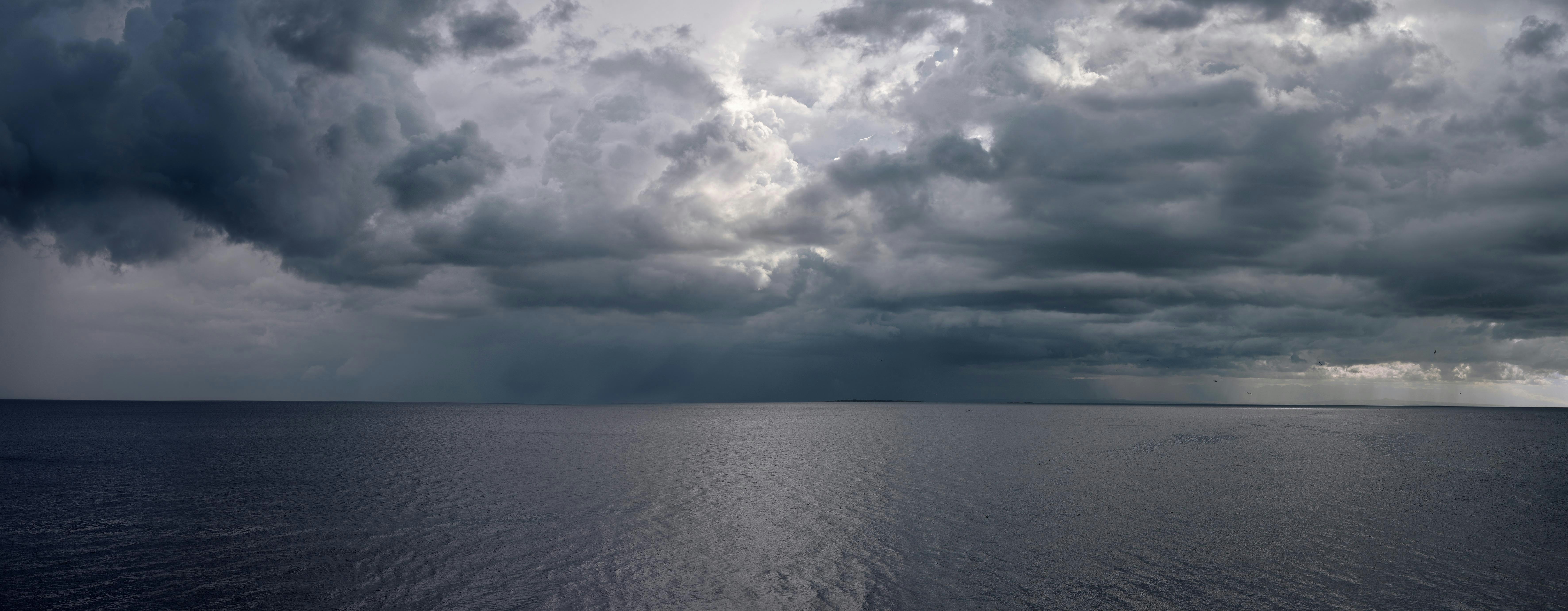A large body of water under a cloudy sky photo – Free Sea Image on Unsplash