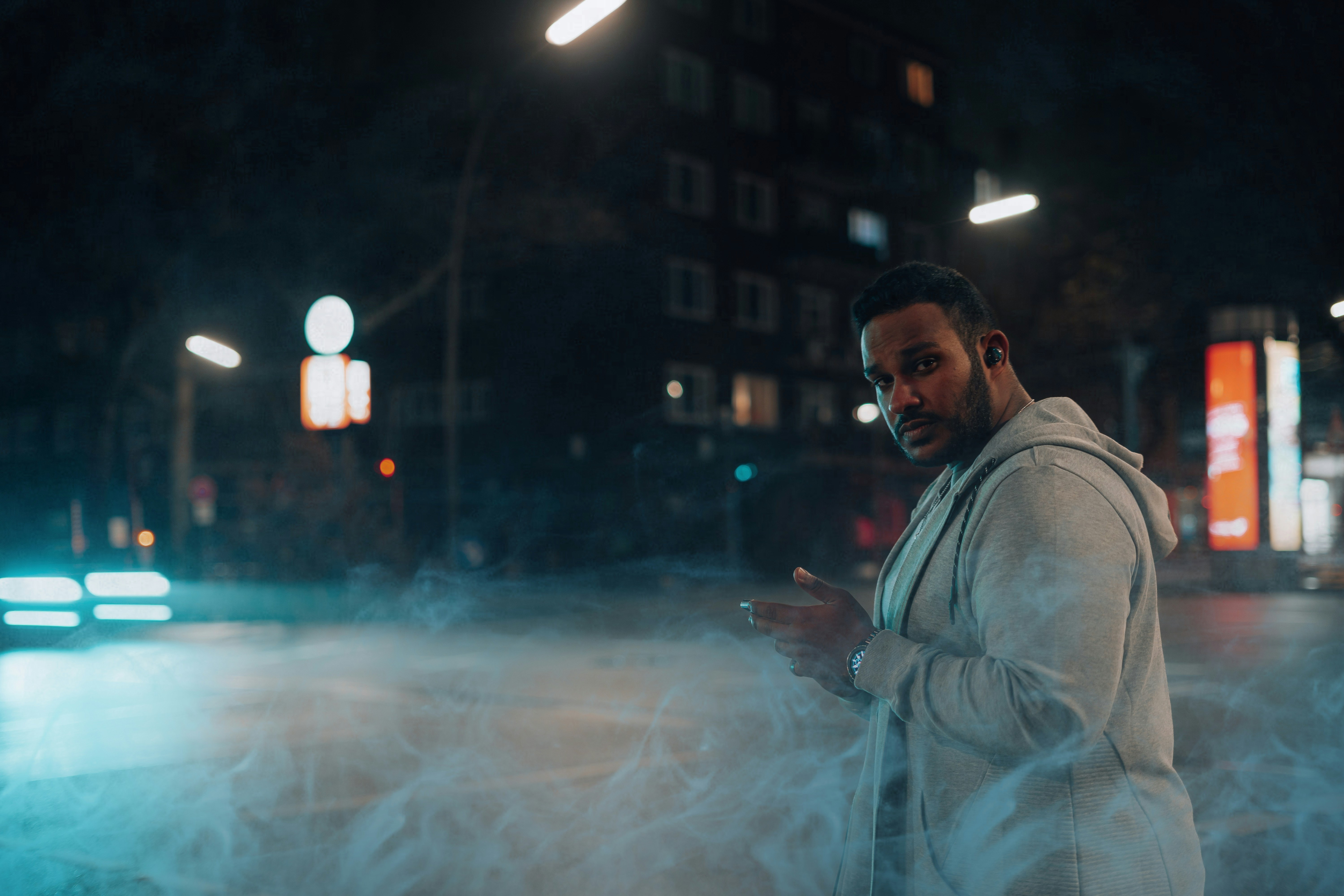 a man standing on a street at night using a cell phone
