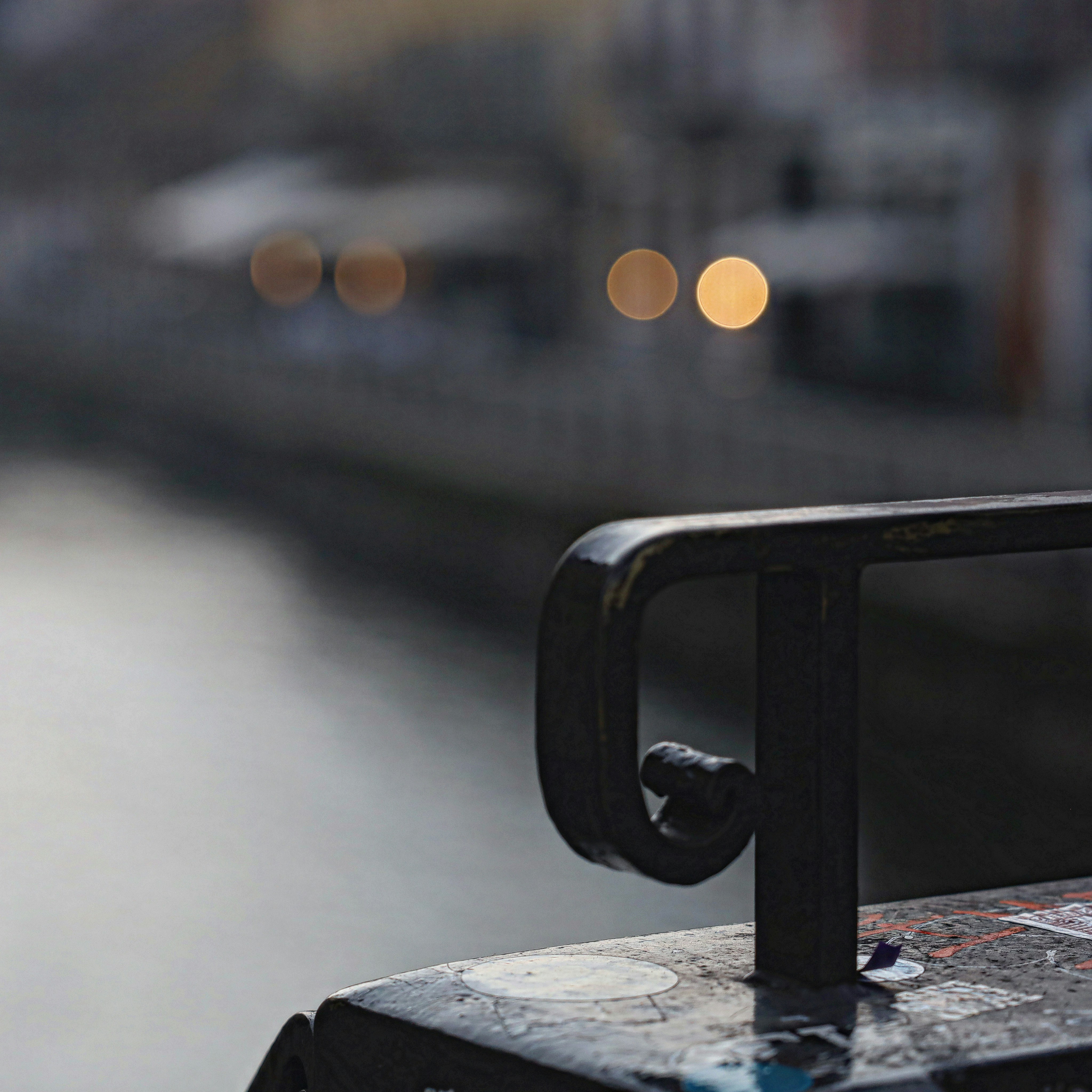 Rusted railing over a blurred canal edge at dusk