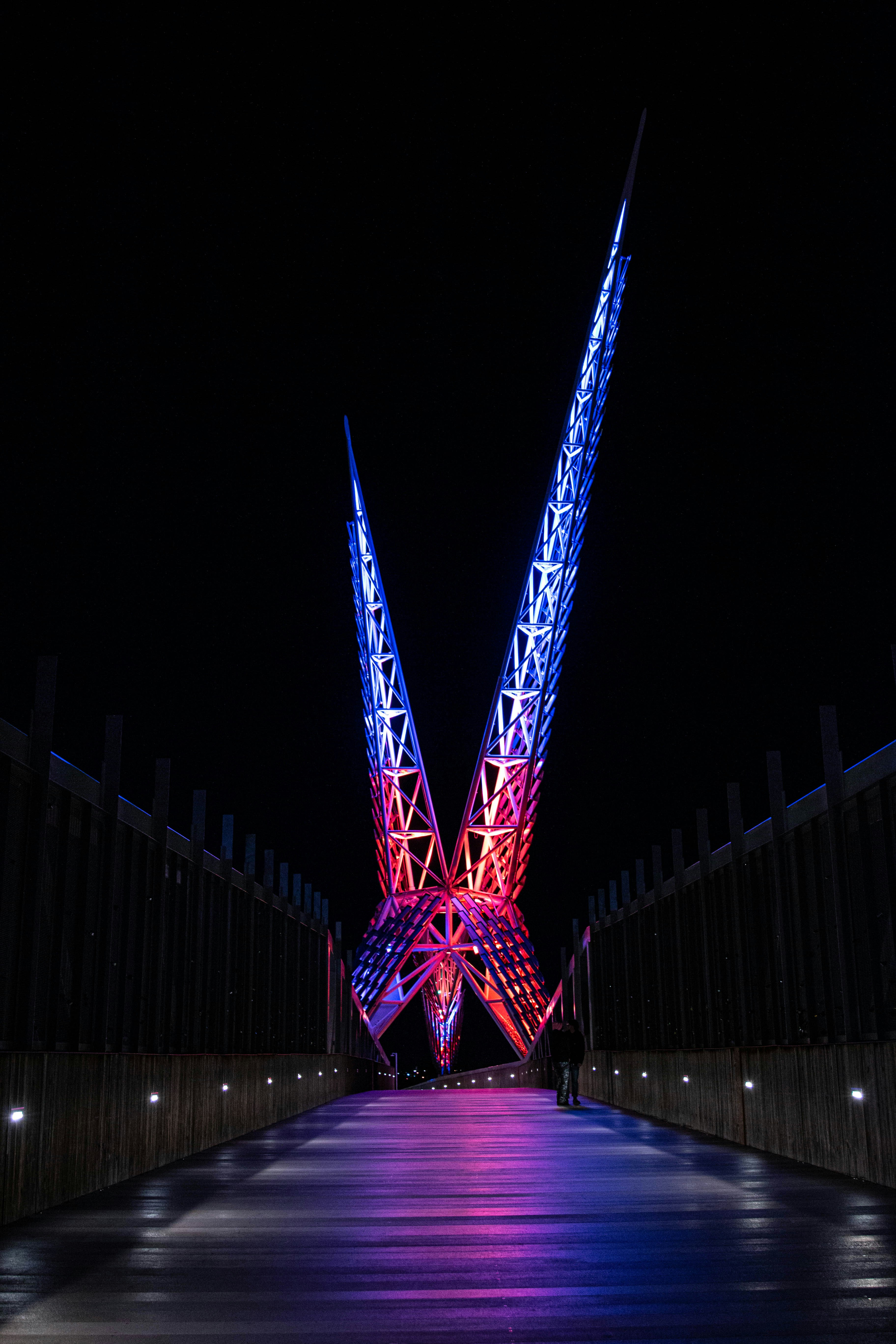 Neon Convergence: Twin Lattice Spires Framing a Night Walkway