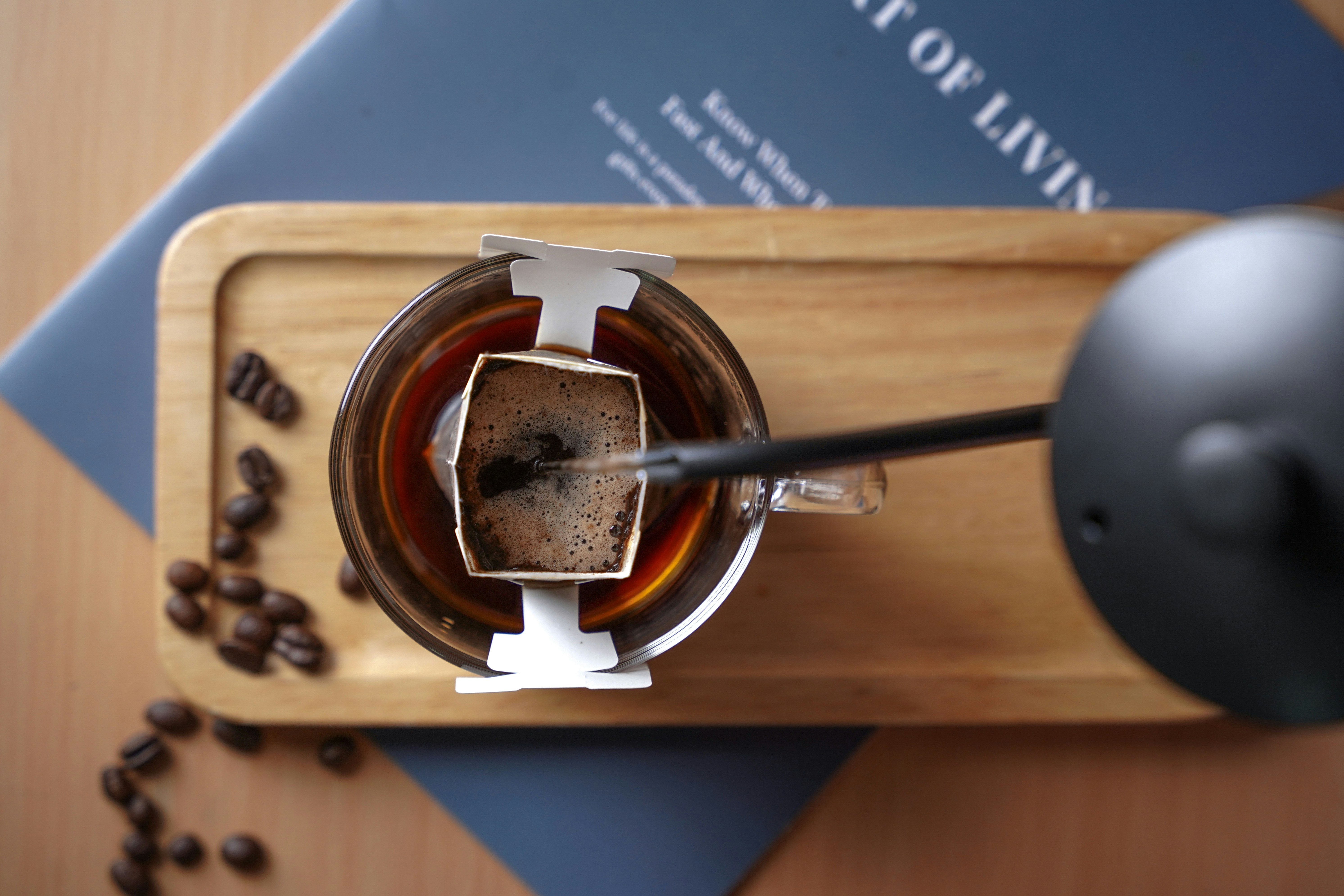 Center Stage: Metal Dripper Over a Glass Cup on a Wooden Tray