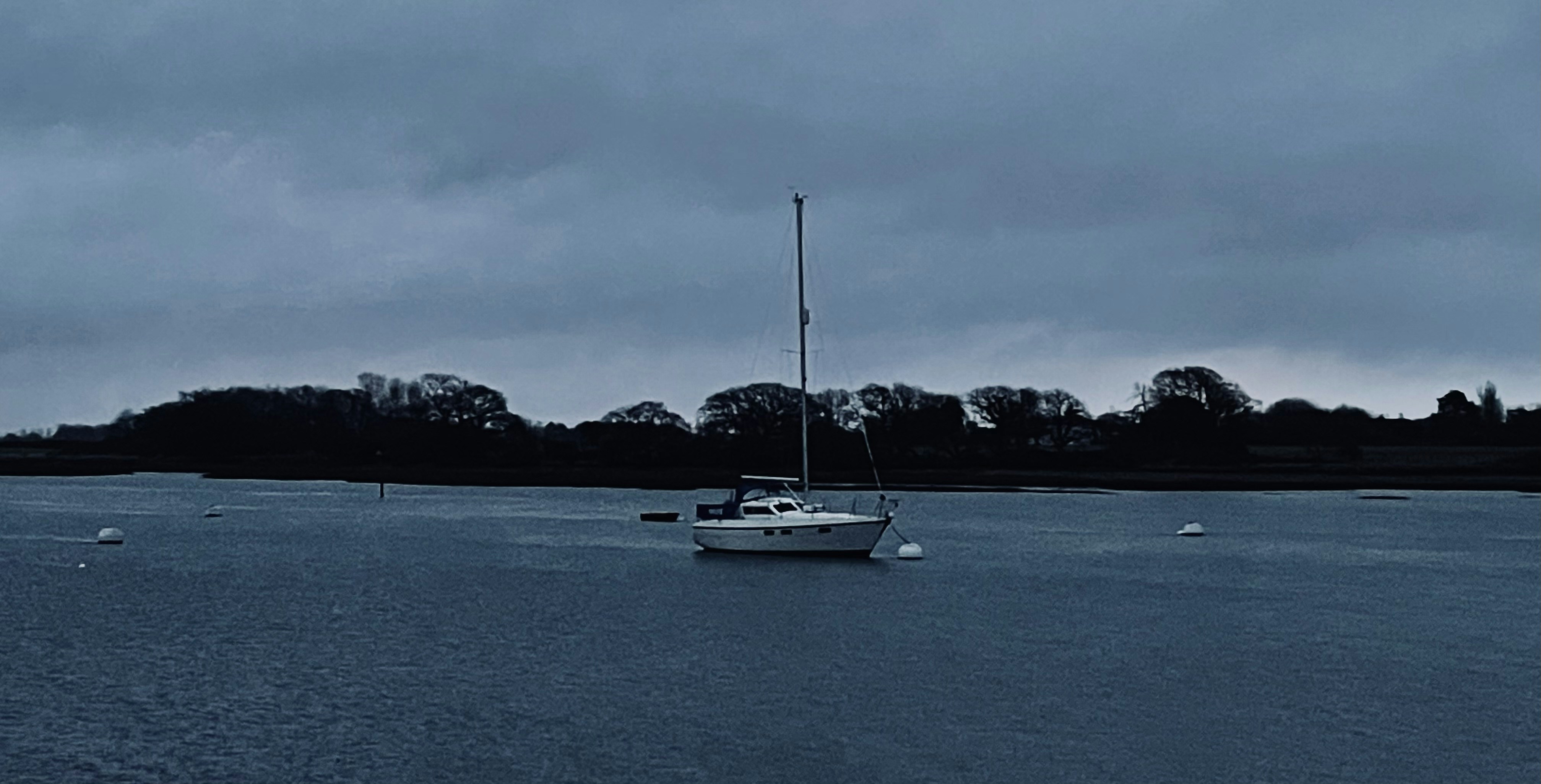 Moody Bay Sail: a lone sailboat beneath a slate-gray horizon