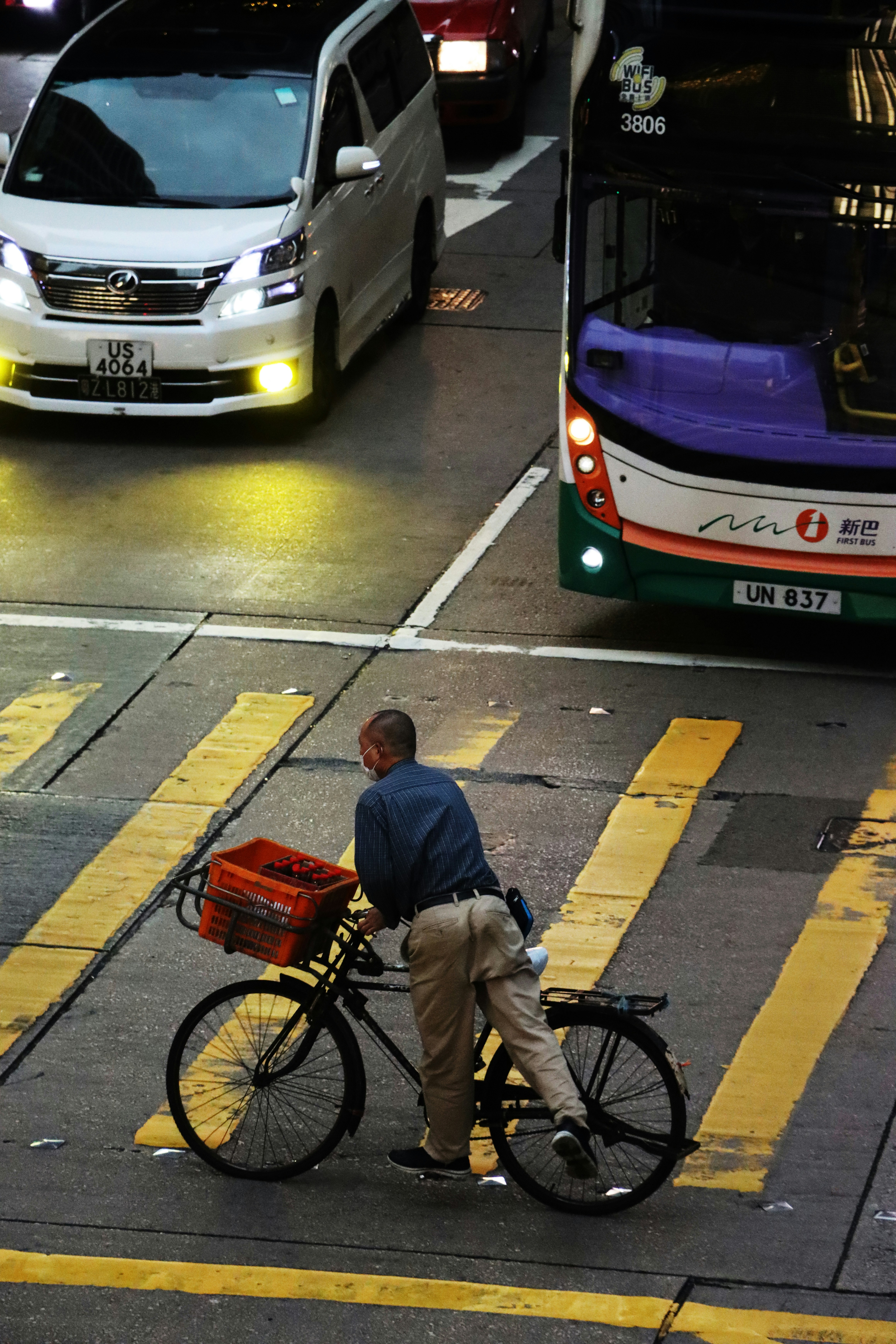 A man riding a bike down a street next to a bus photo – Free Central ...