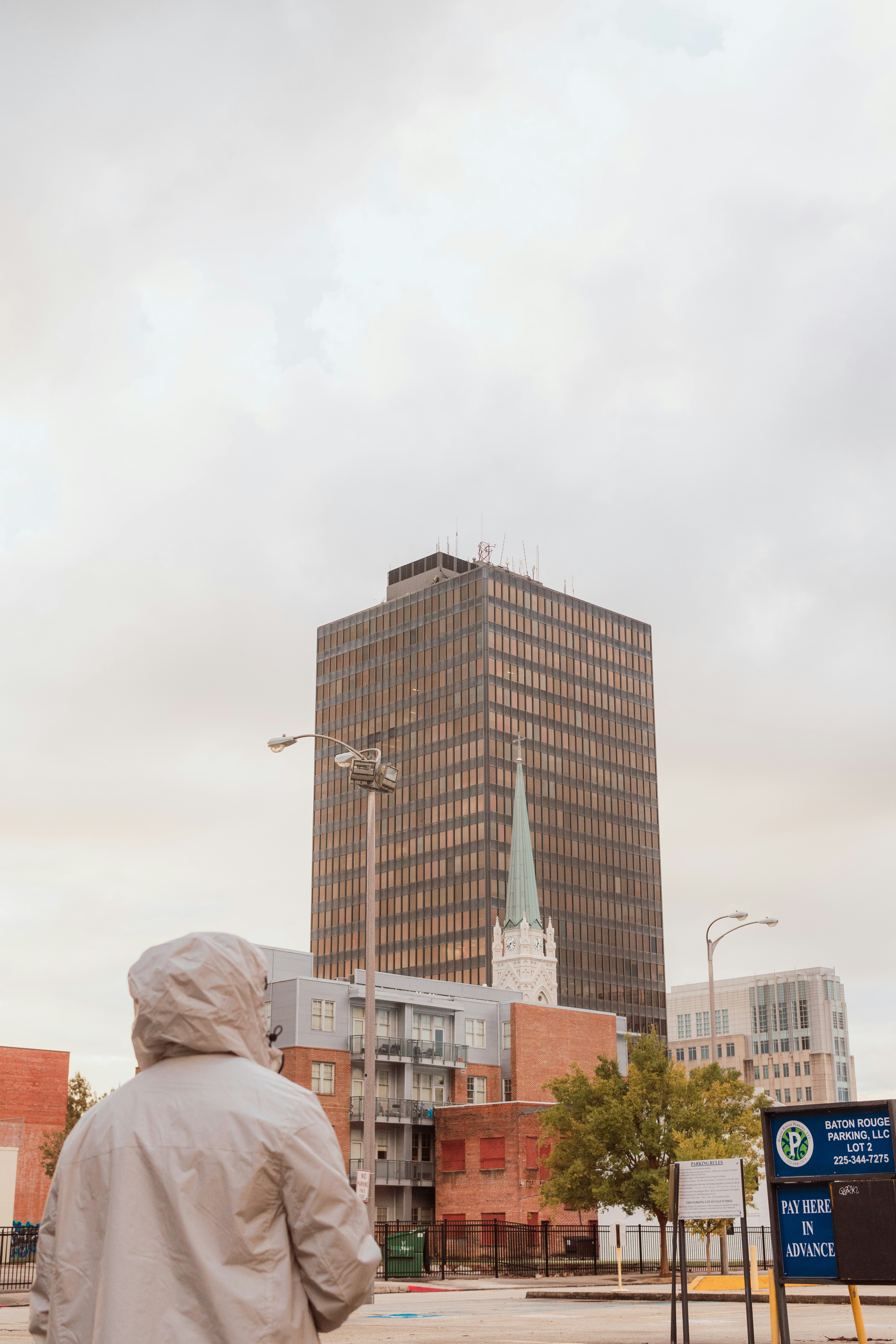 A person standing in front of a tall building photo – Free Baton rouge ...