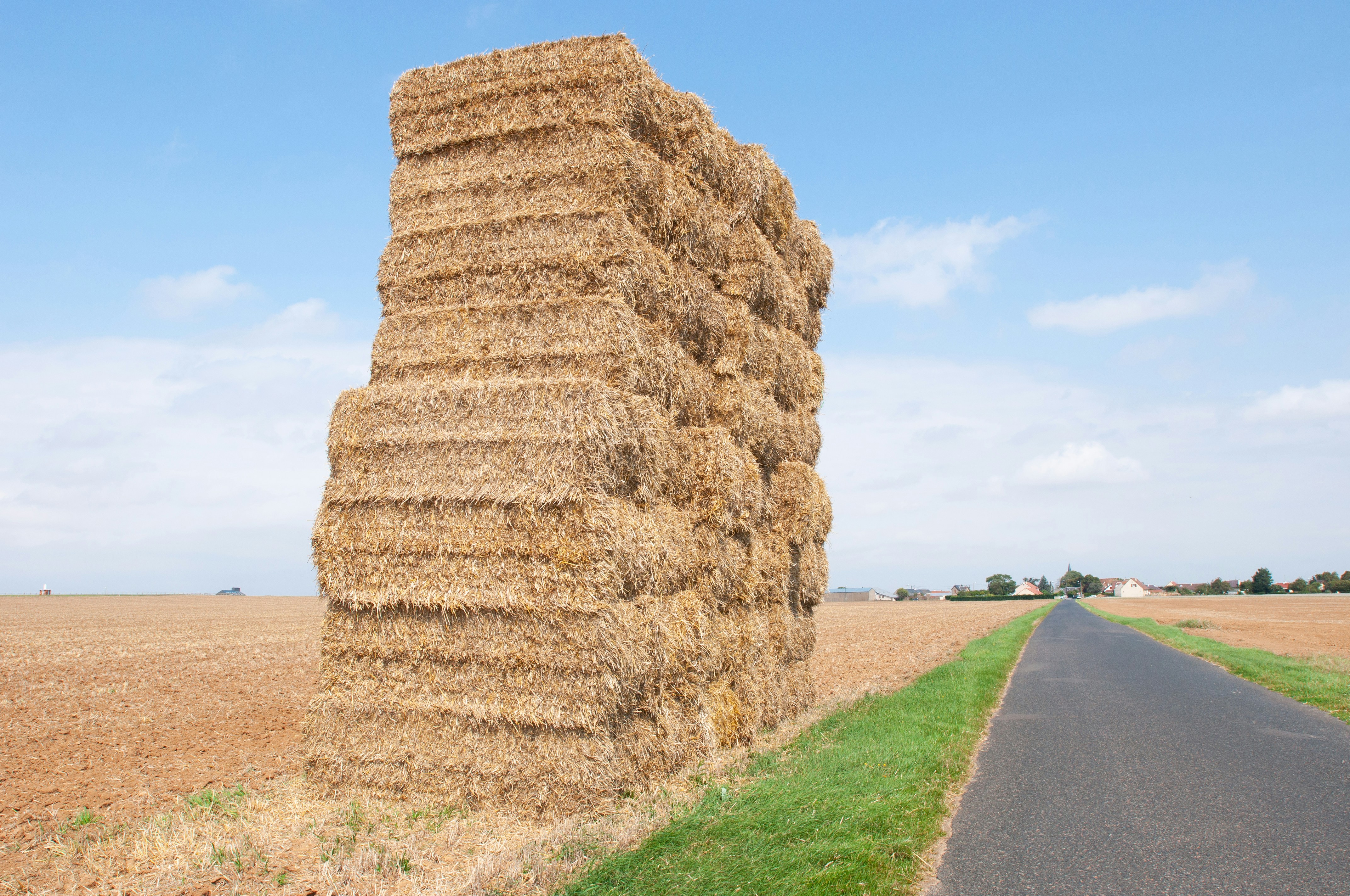 A large stack of hay sitting on the side of a road photo – Free France ...
