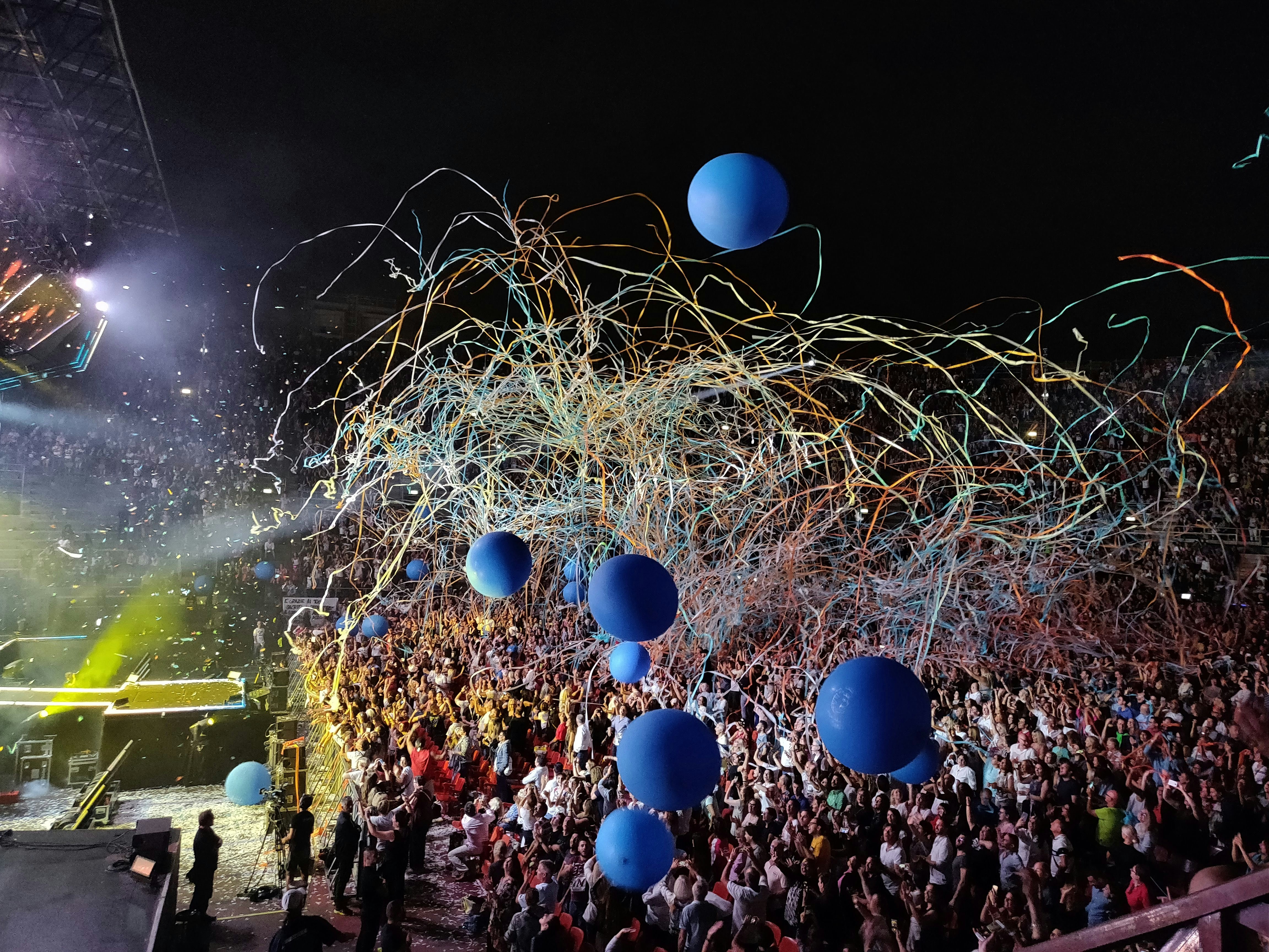 A crowd of people at a concert with blue balloons photo – Free Human ...
