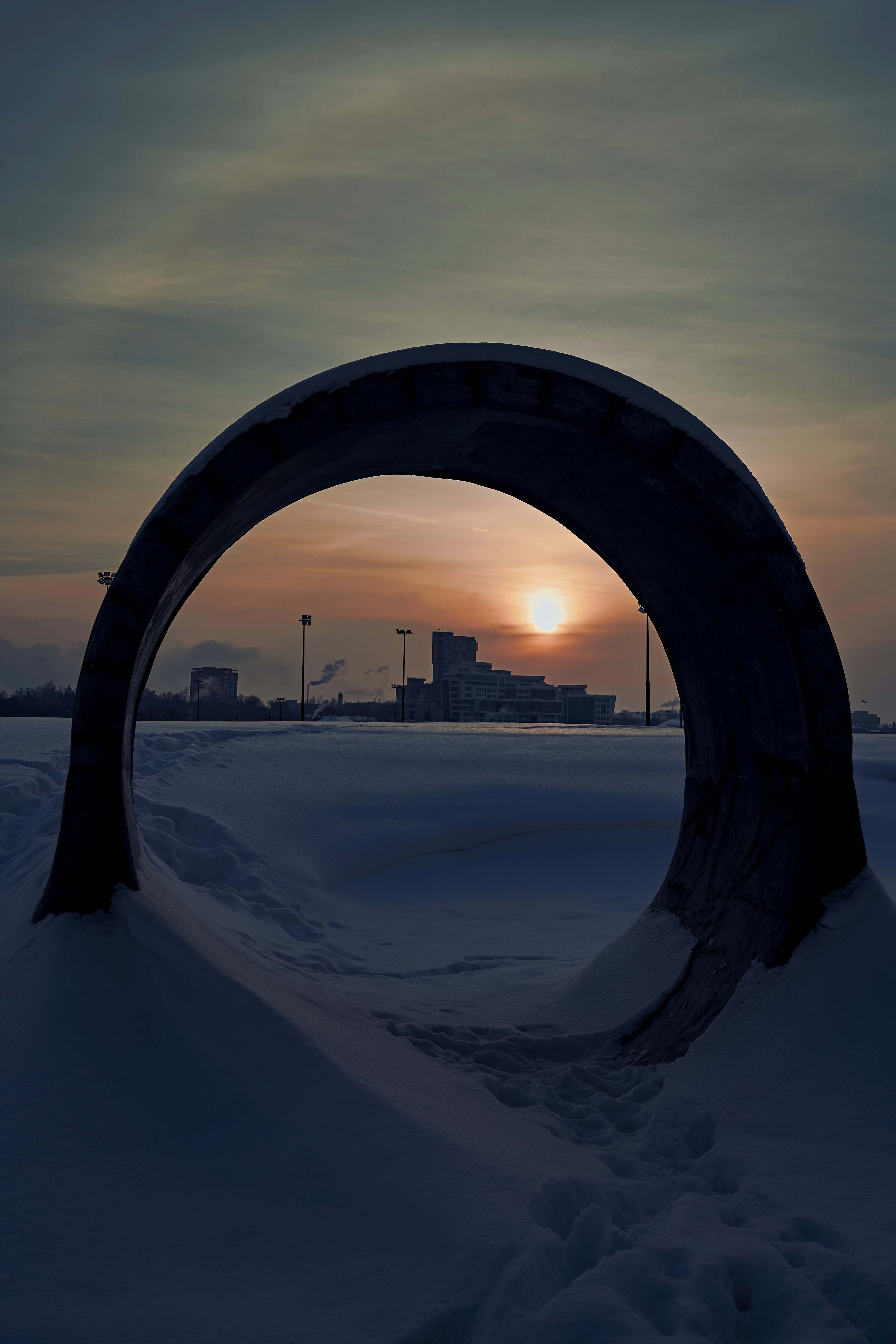 Sunset Framed by a Circular Gate on Winter Plain